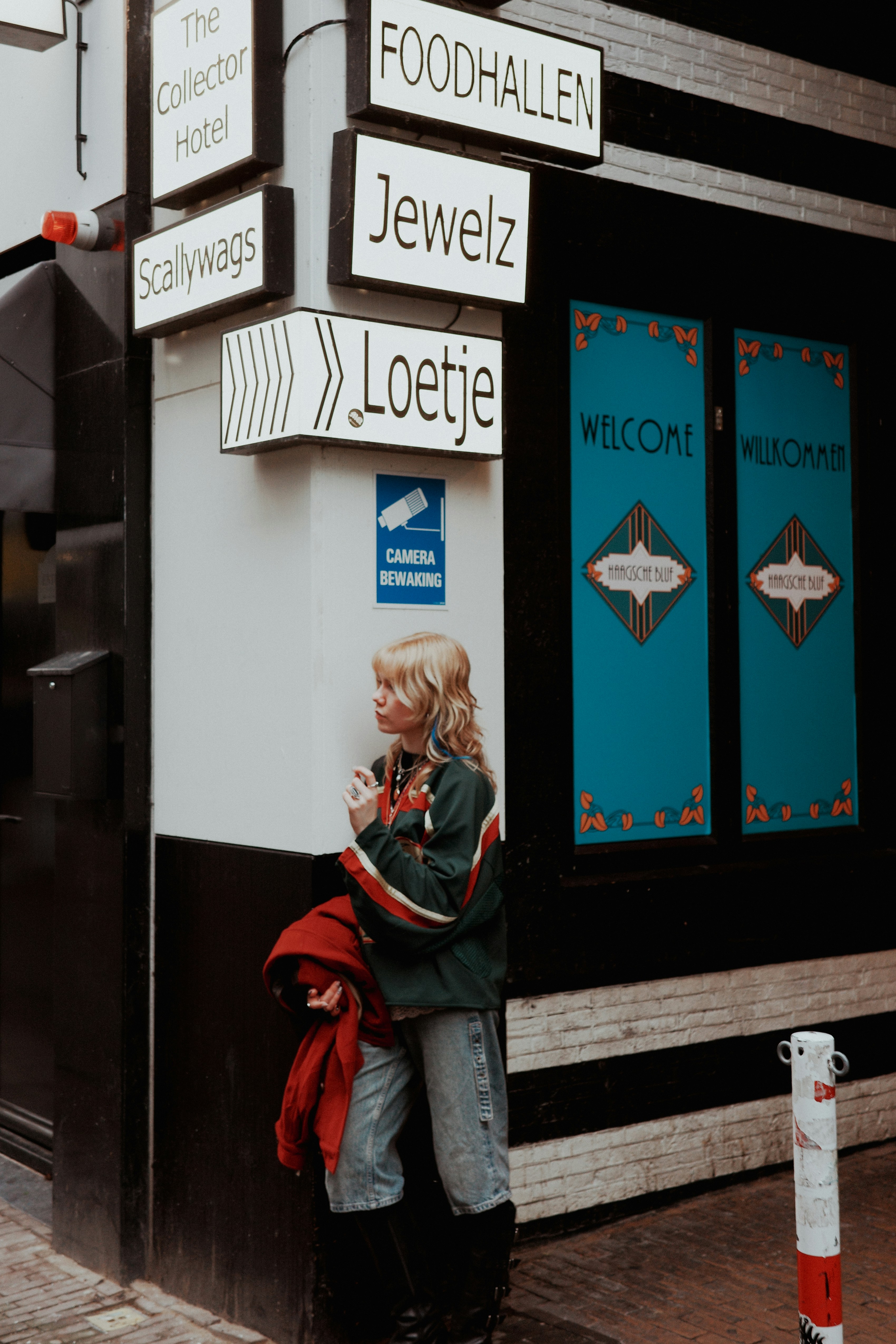 A woman leaning against a building on a sidewalk photo – Free Street ...