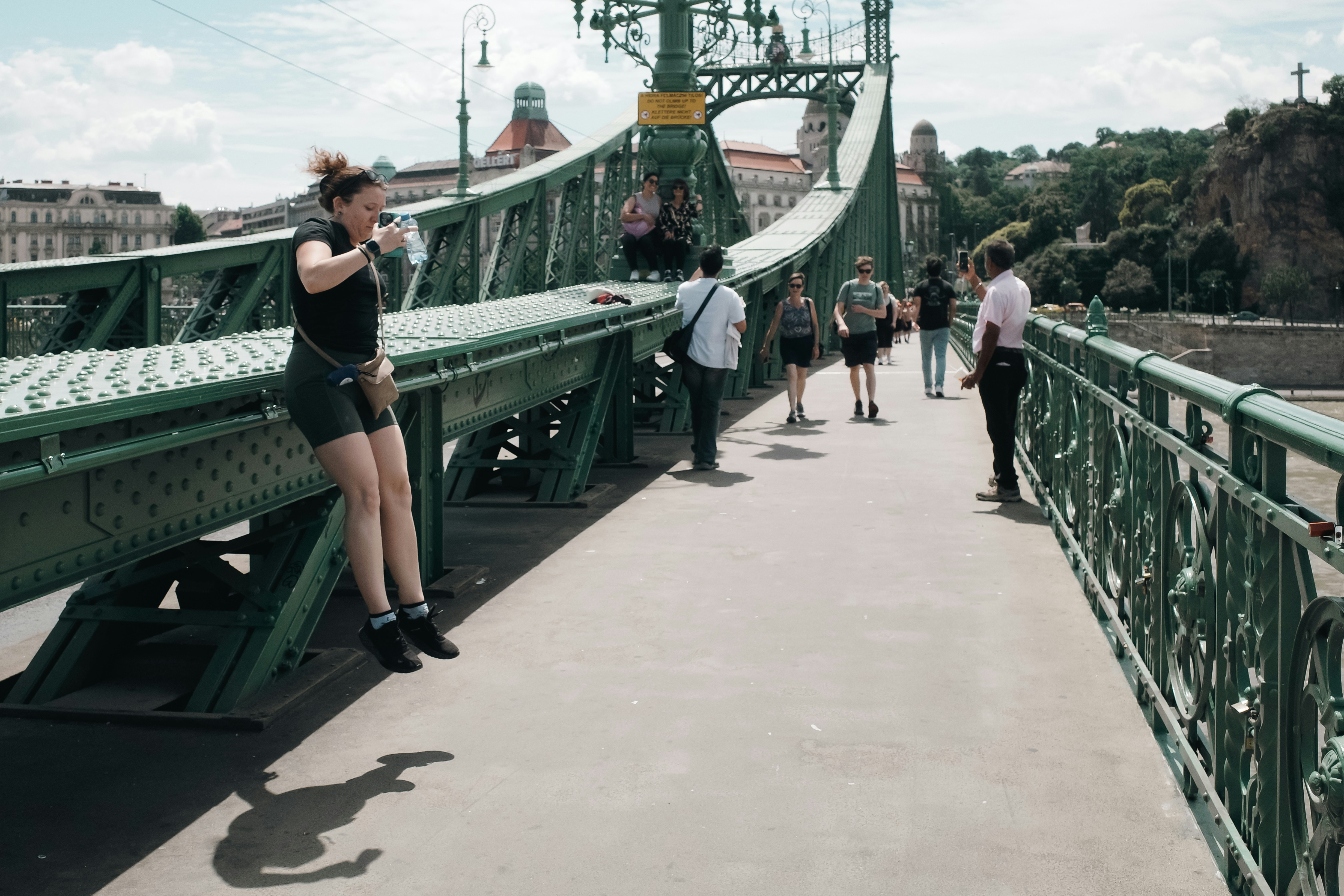 Portrait on the Green Bridge: A Solo Figure Framed by Pedestrian Flow