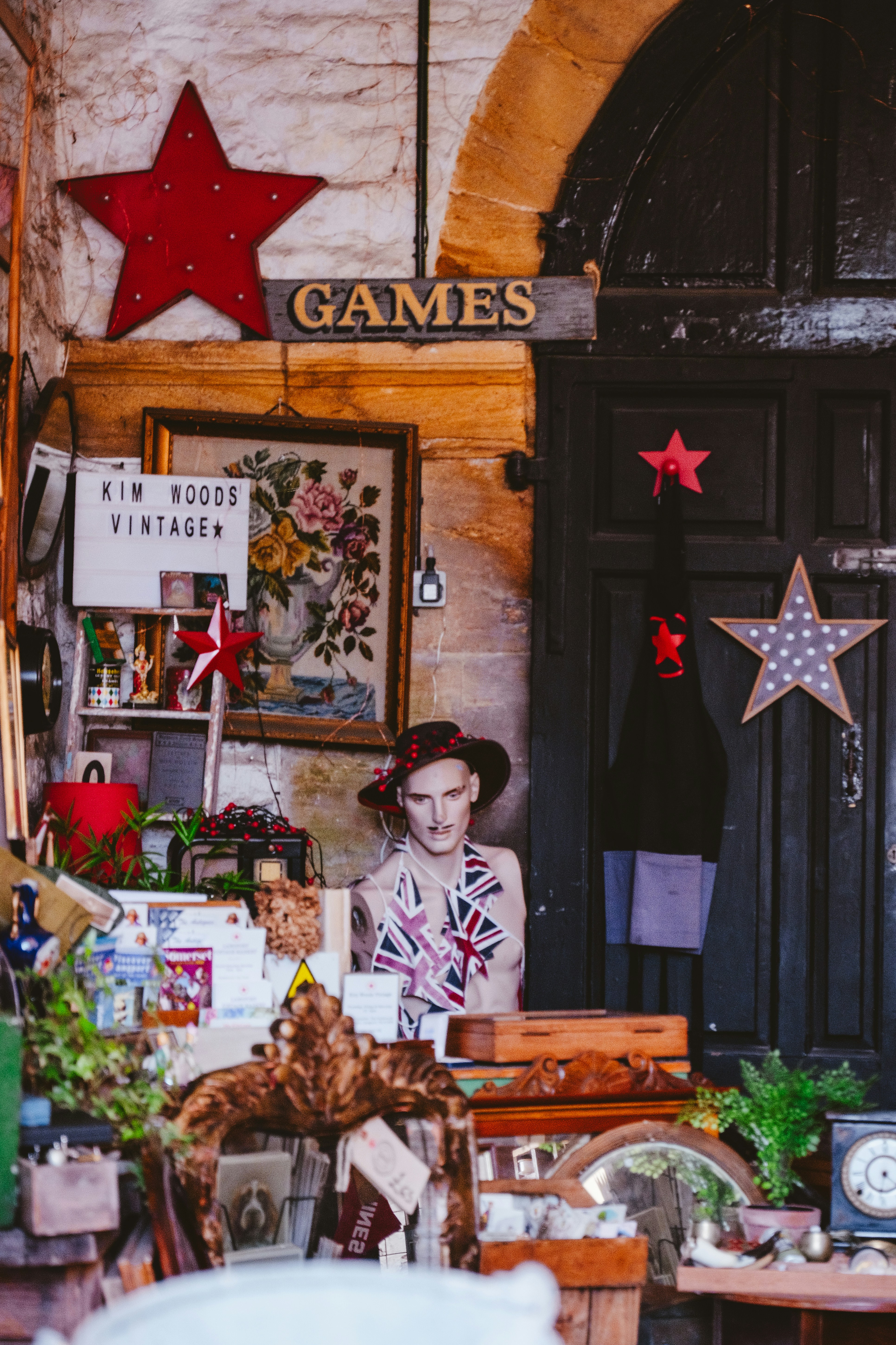 A vibrant vintage shop interior featuring quirky decorations, a mannequin dressed in a striped outfit, and various collectibles. The atmosphere is lively and inviting.