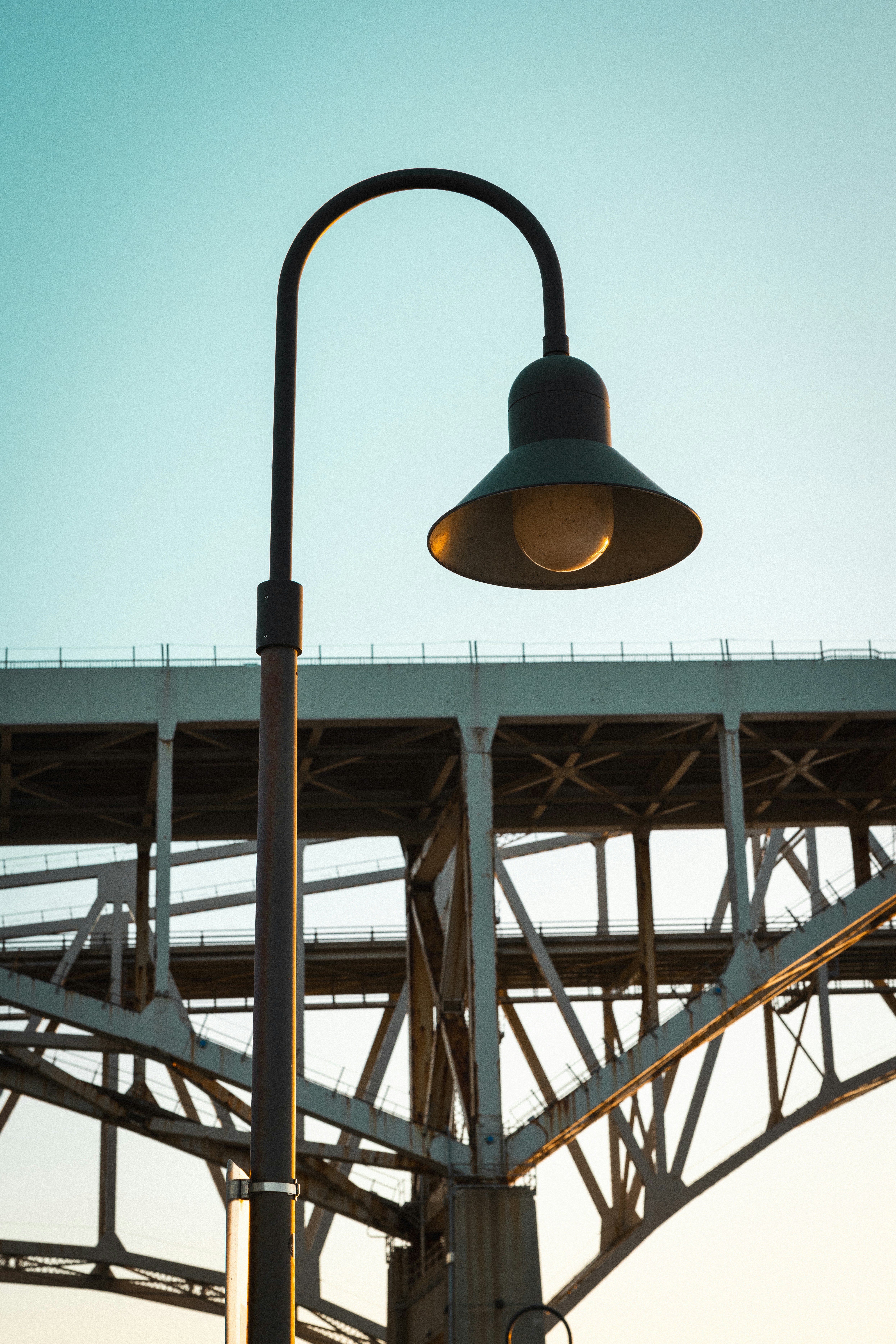 A street light on a metal pole under a bridge photo – Free Port huron ...