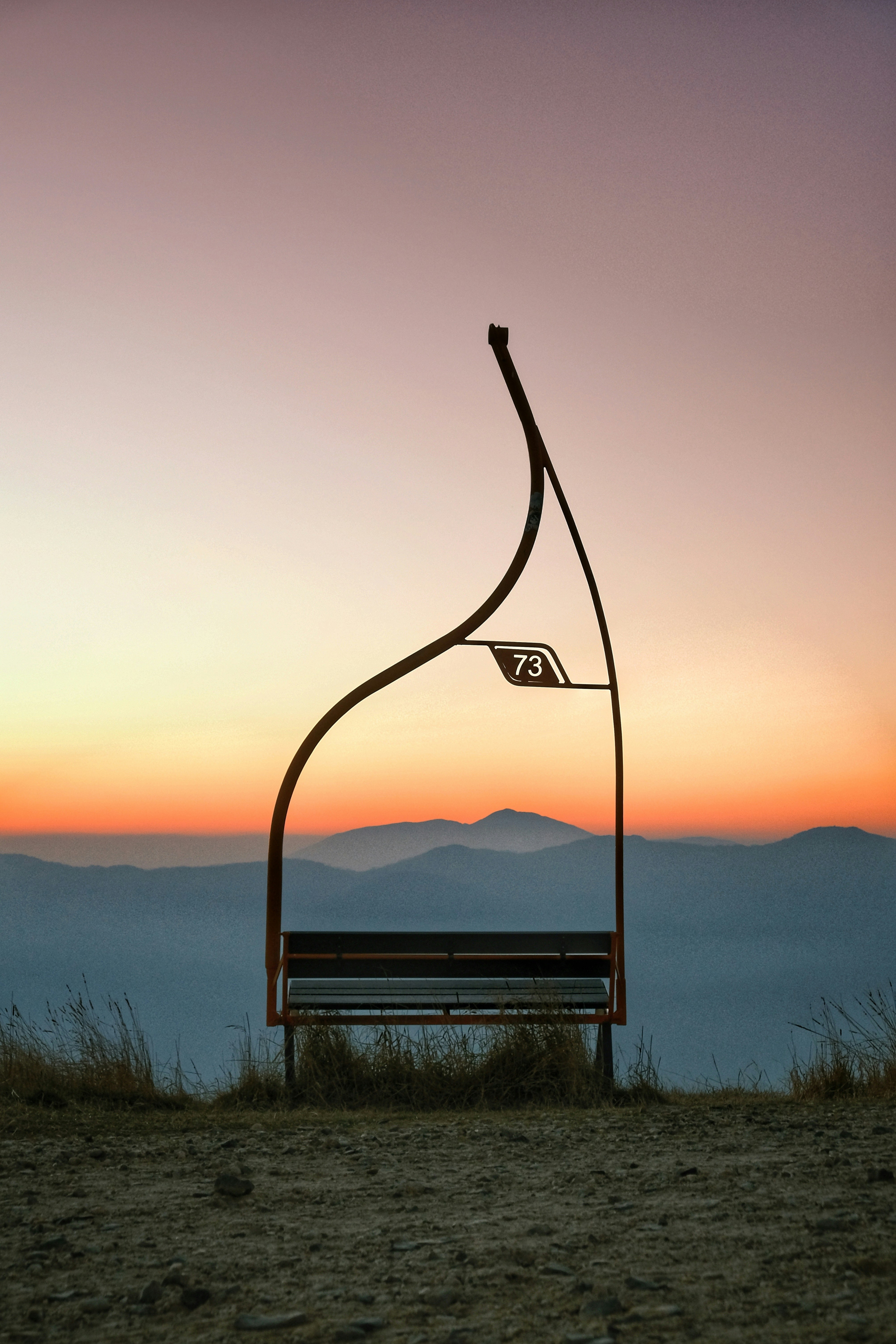 Twilight Arc: A Curved Bench Framed by Sunset on the Ridge