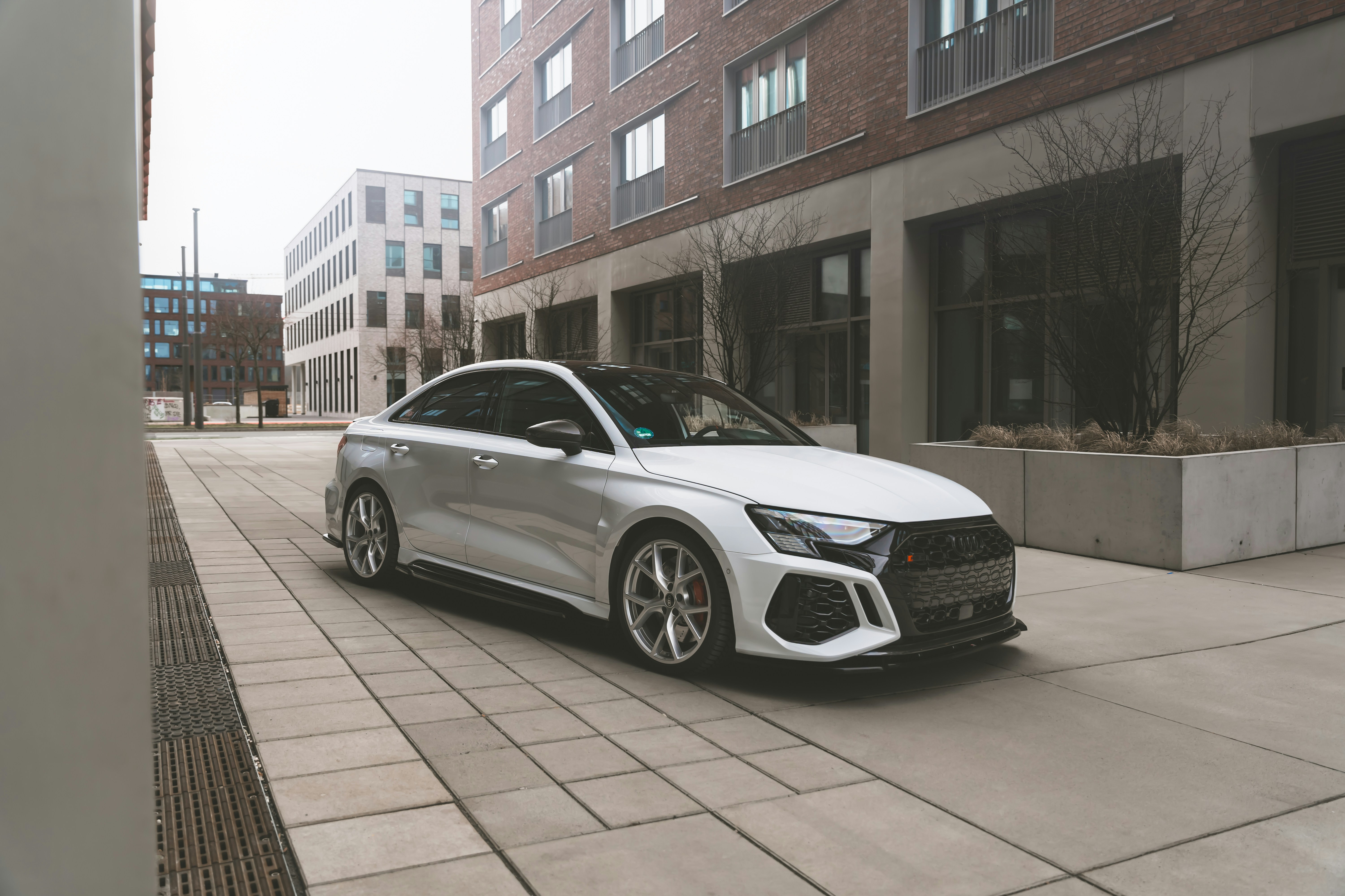 A white car parked in front of a building photo – Free Grey Image on ...