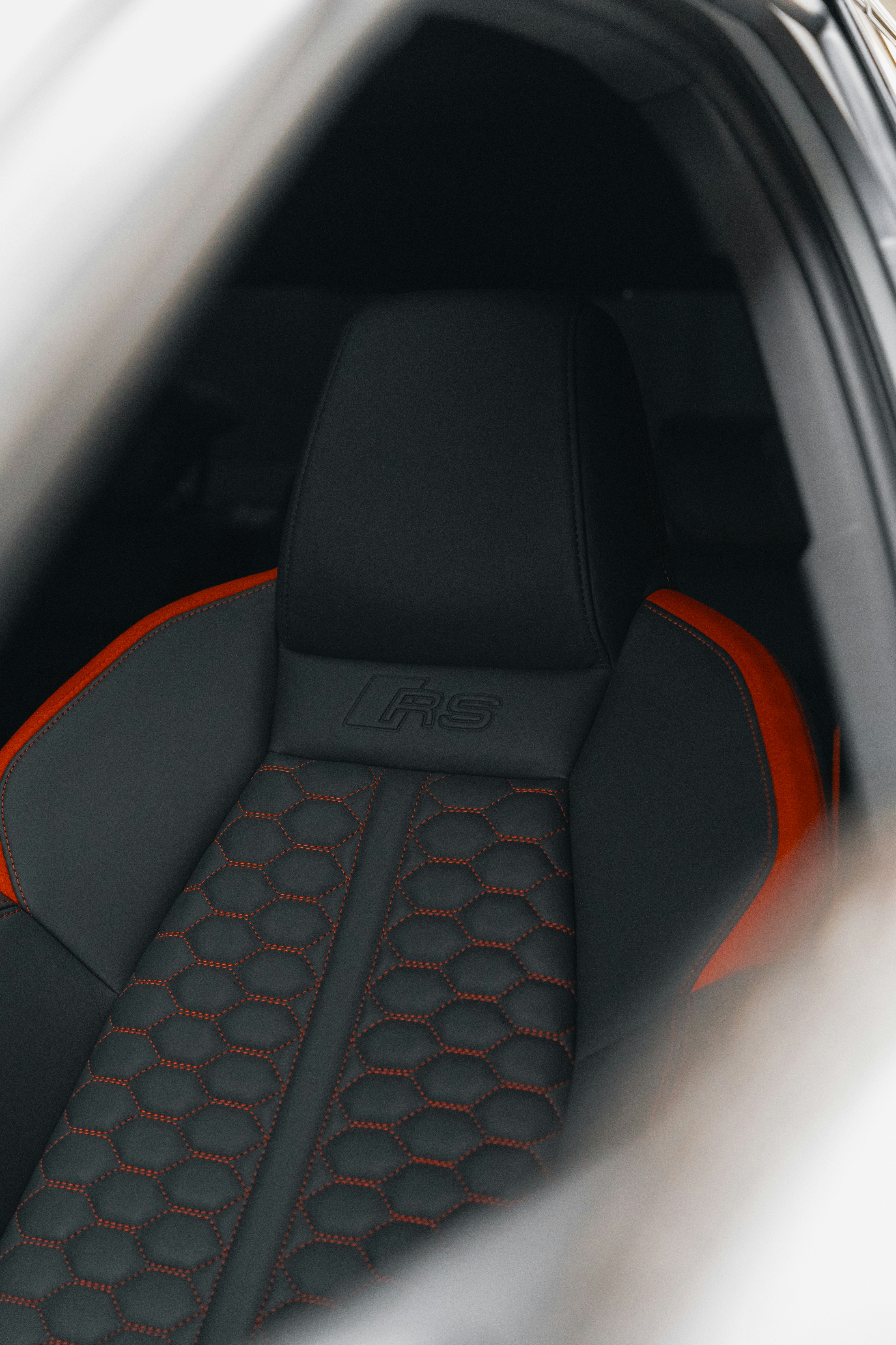 RS Orbit: Red-Stitched Hexagon Seat Center in a Car Cabin