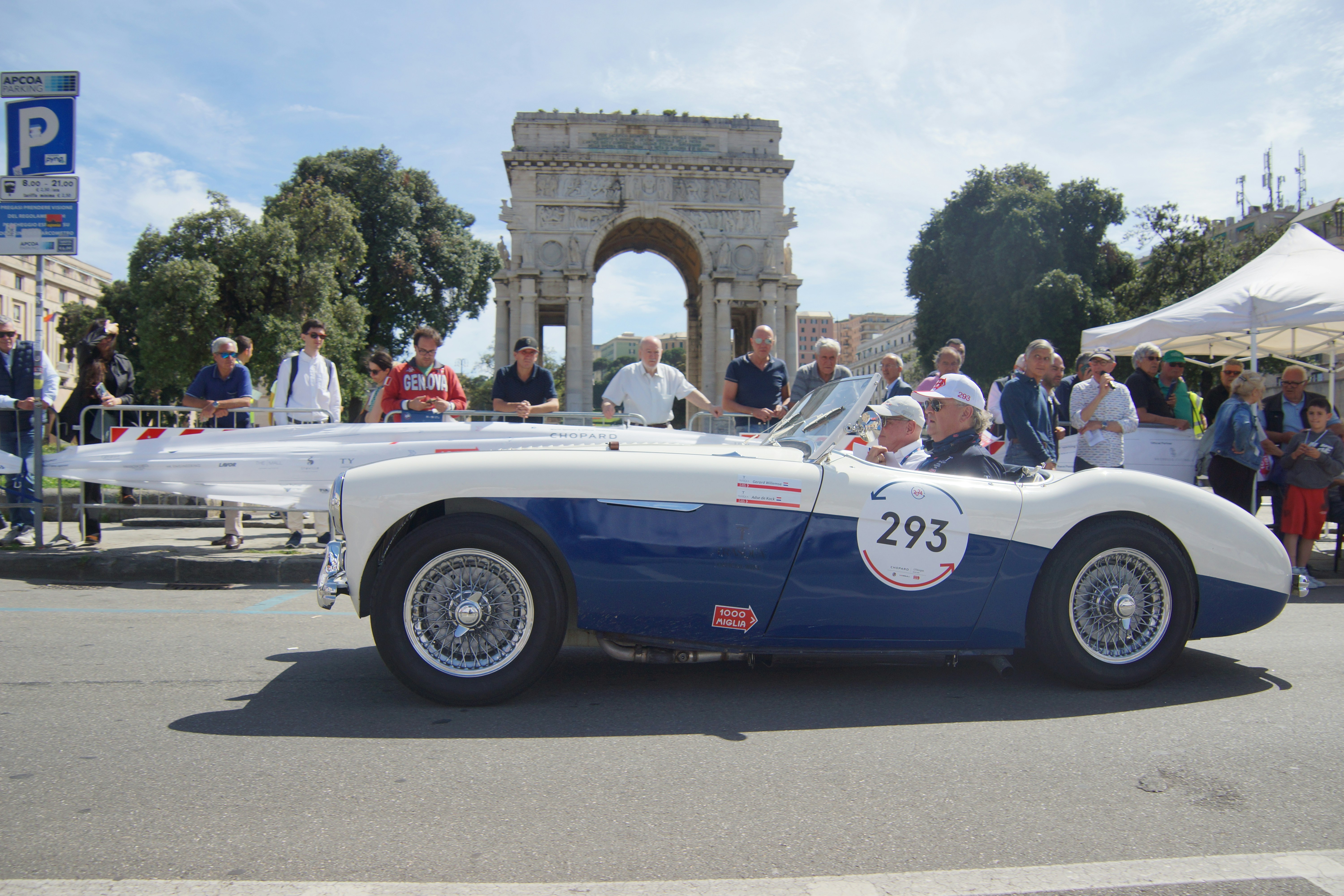 A blue and white race car driving down a street photo – Free Genova ...