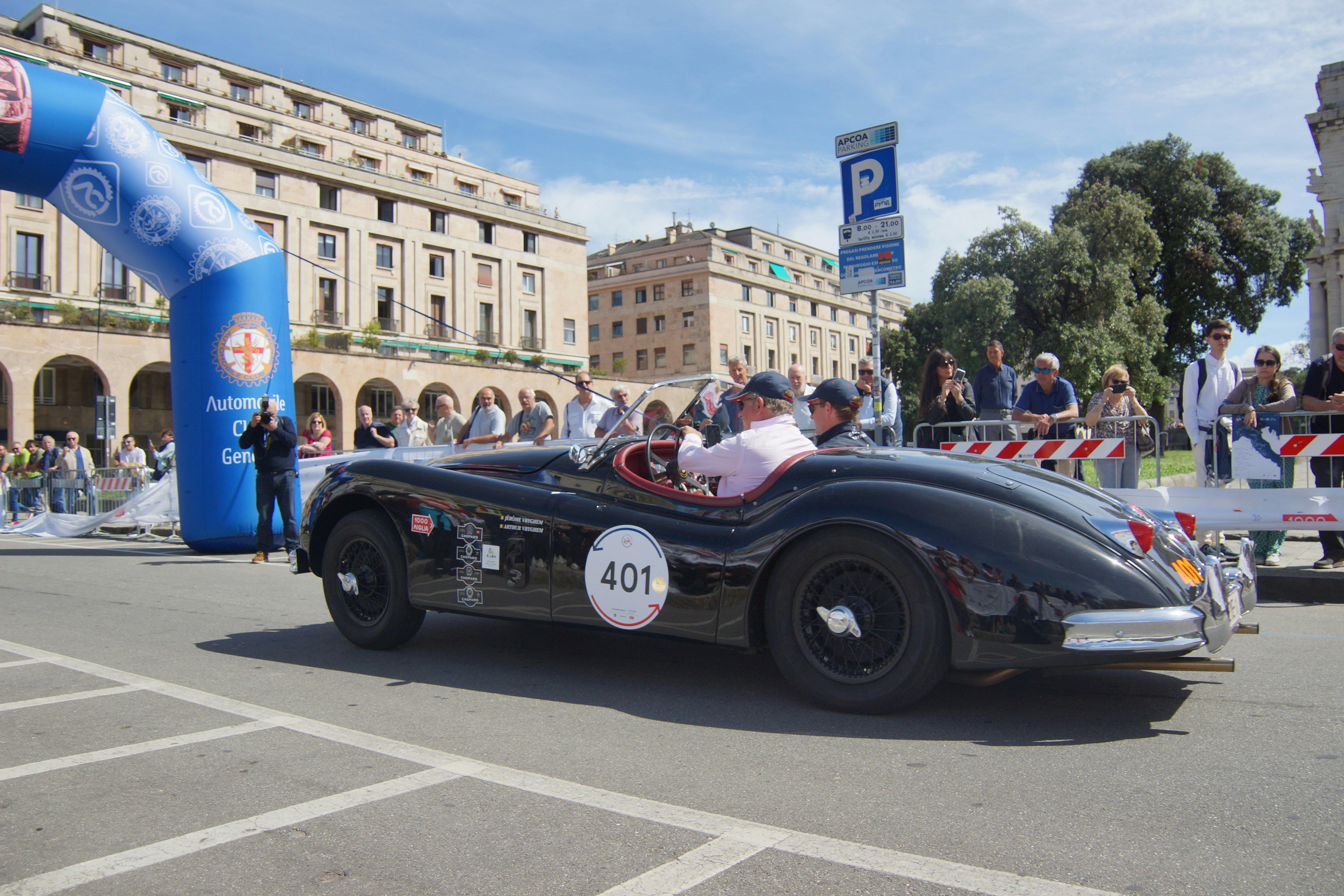 A vintage race car driving down a city street photo – Free Genova ...
