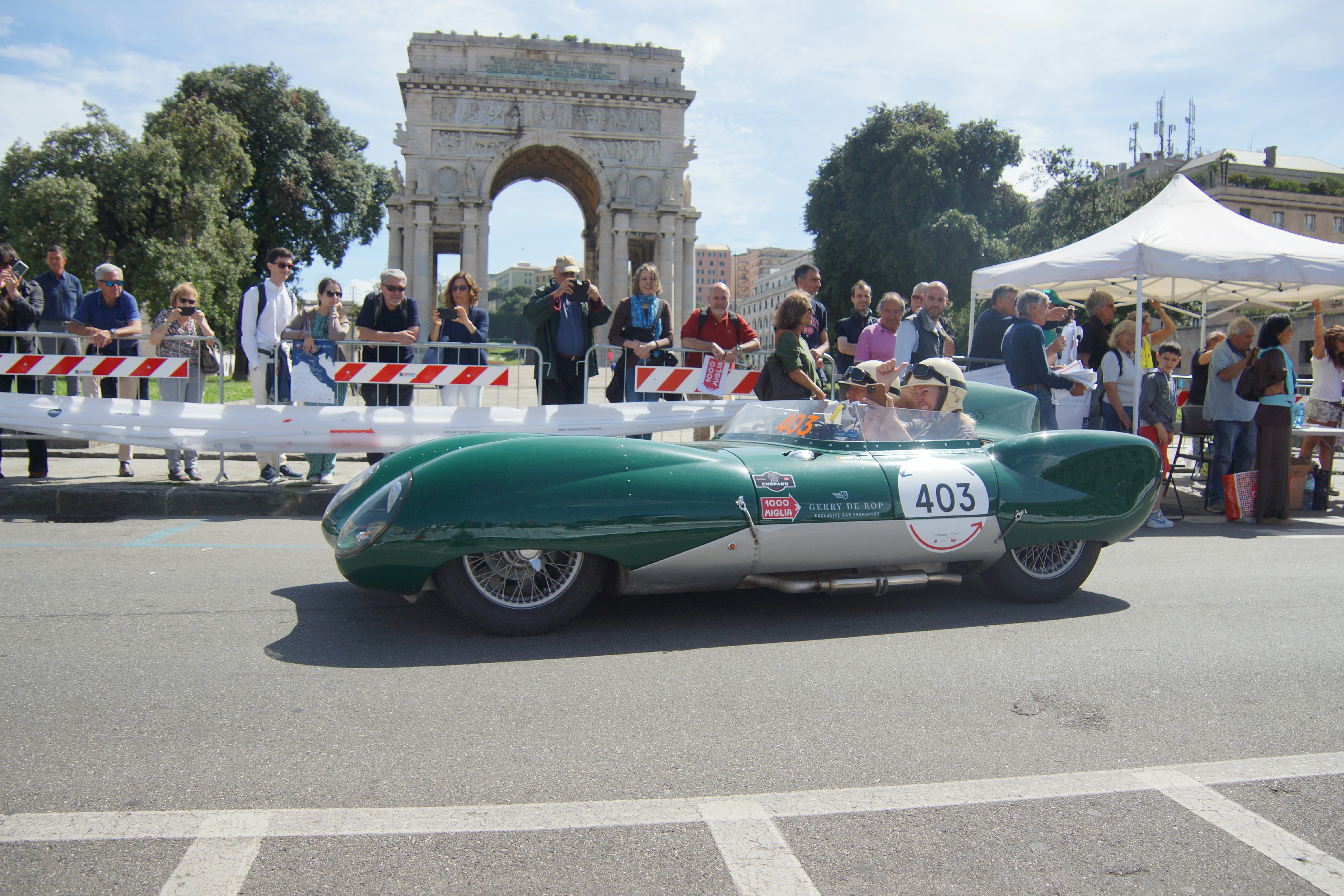 A green race car driving past a crowd of people photo – Free Genova ...