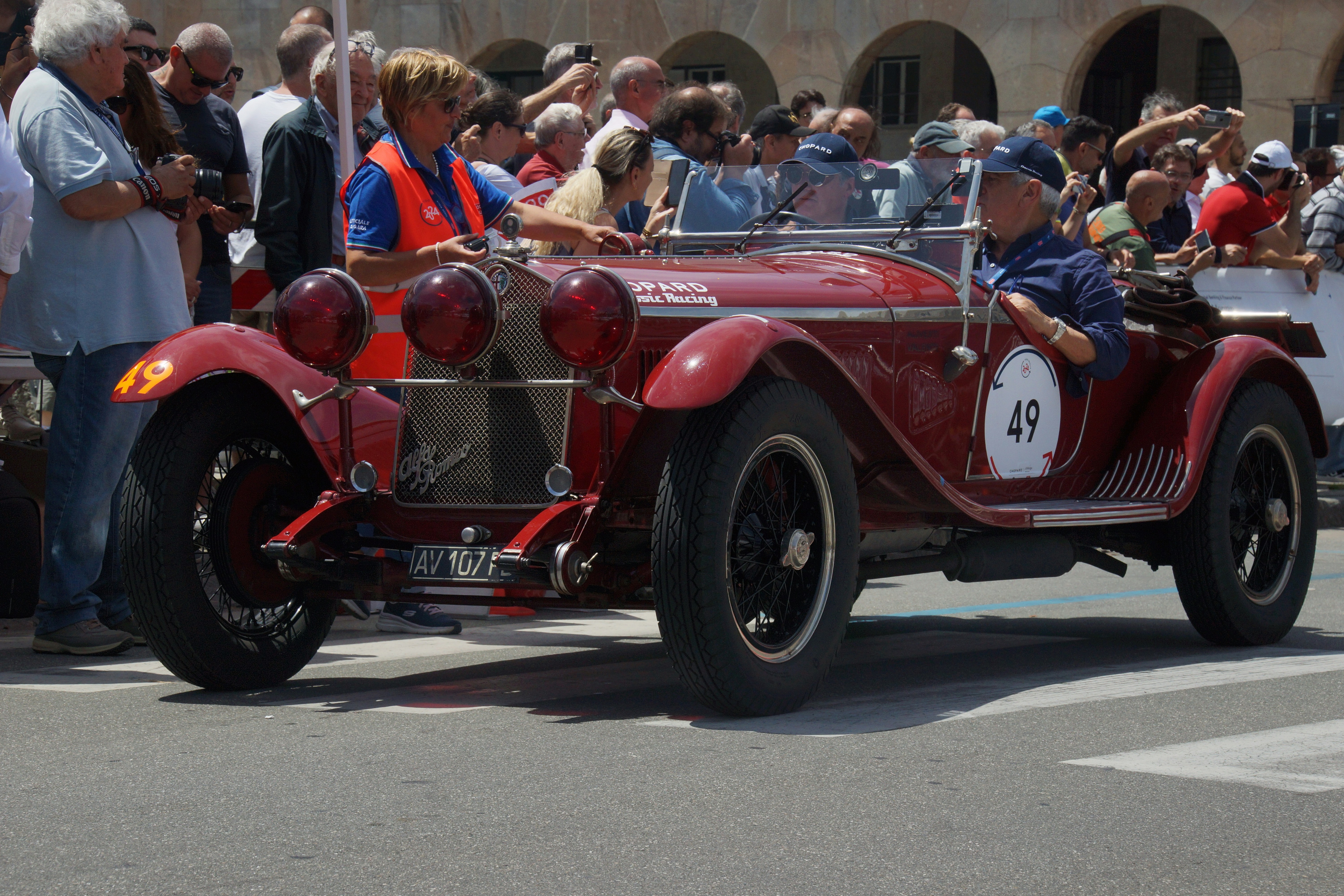 A red car with a number on it driving down a street photo – Free Genova ...