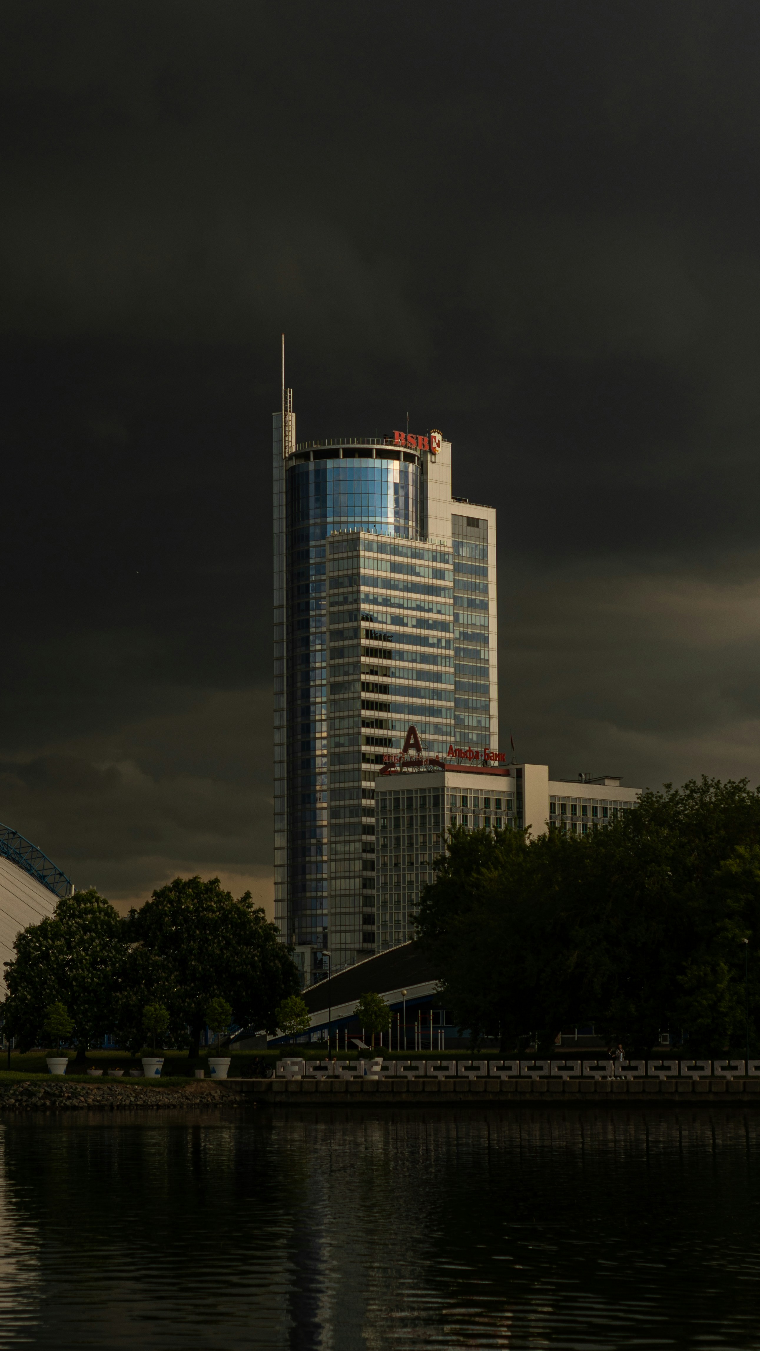 Skyscraper by the river at dusk