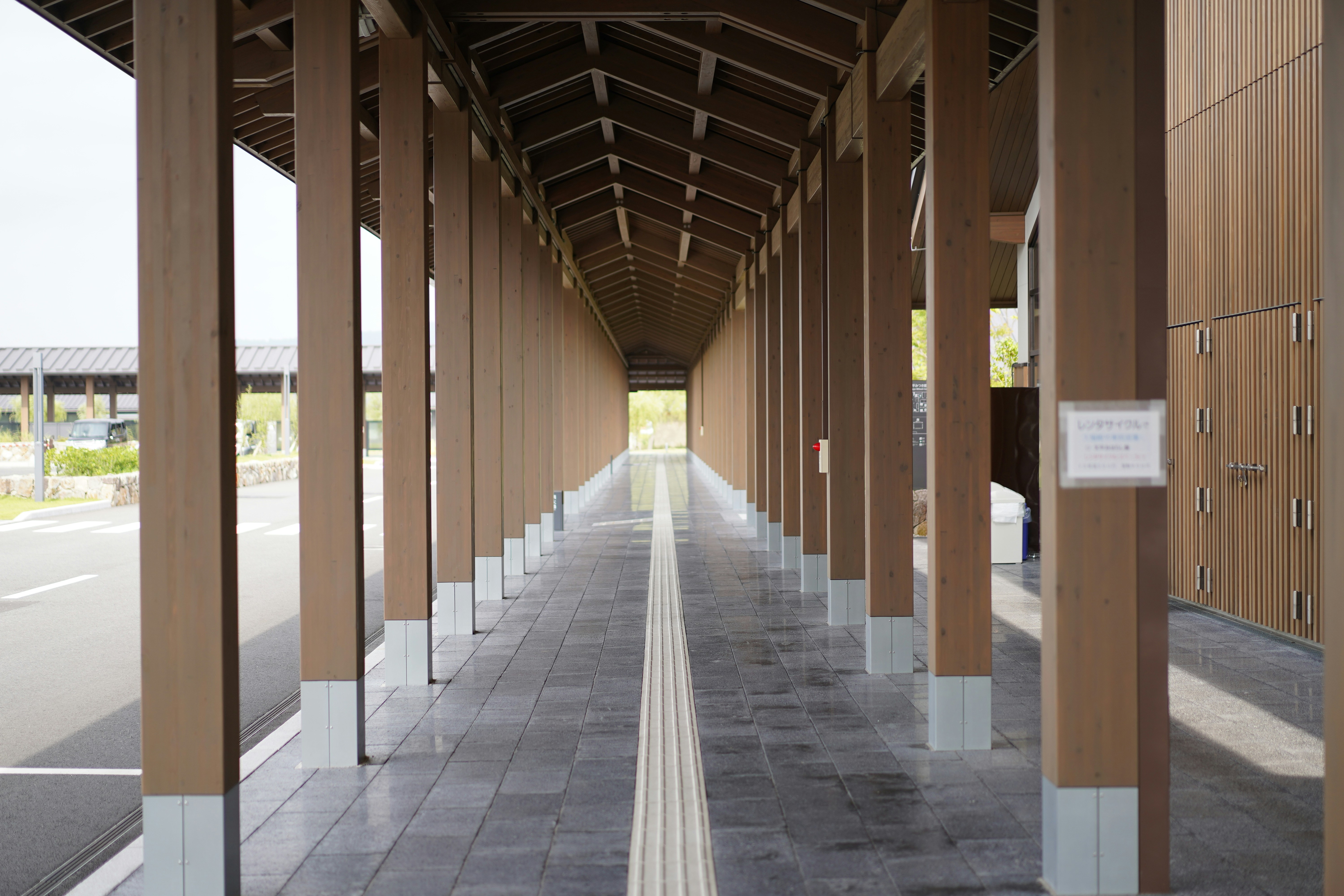 A long walkway lined with wooden poles and benches photo – Free ...
