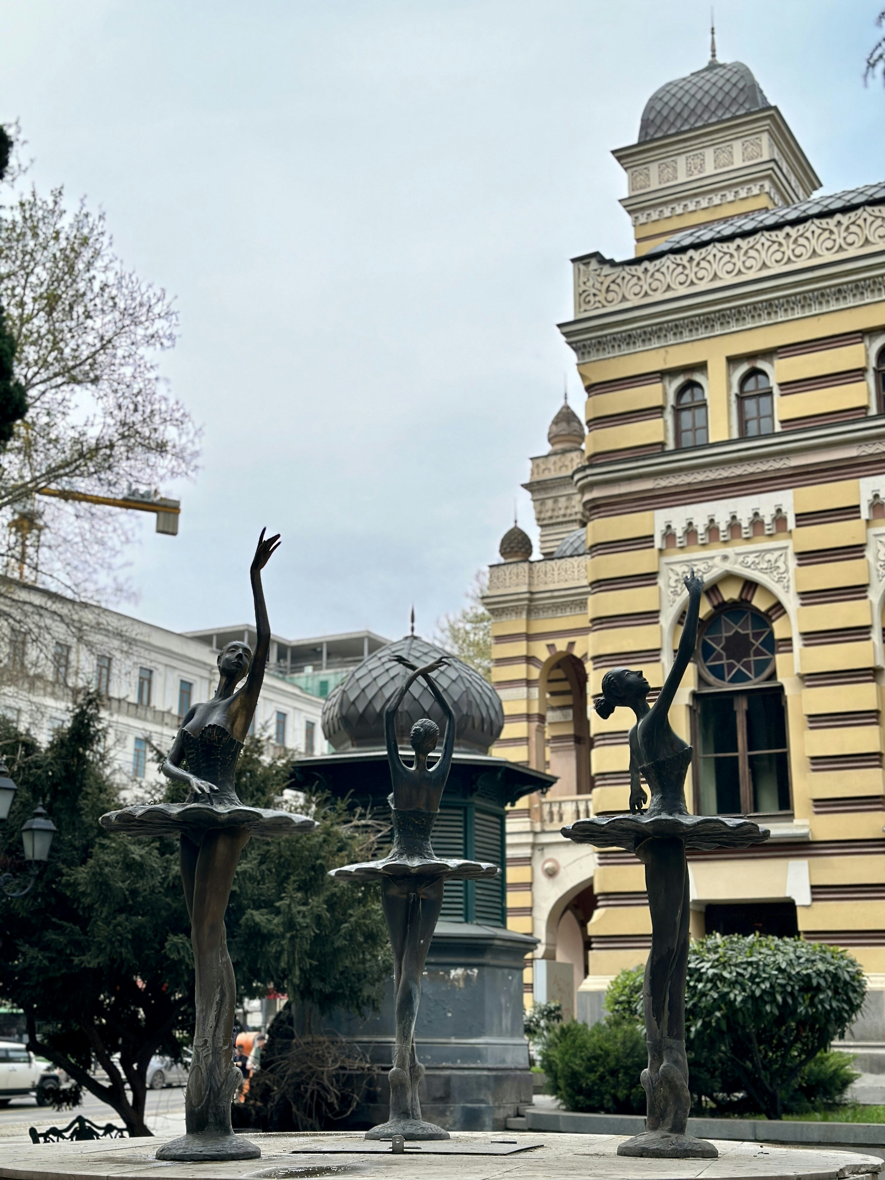 Bronze Ballerinas Framing a Sunlit European Facade