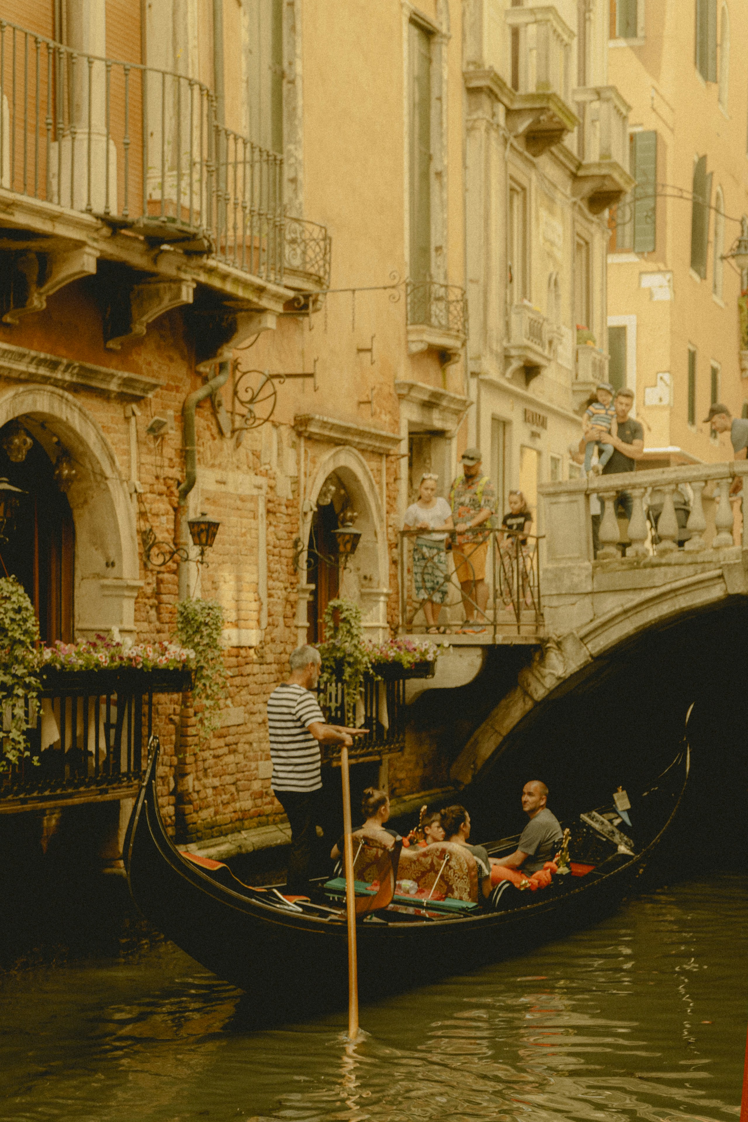 Gondola Glide Under Golden Venetian Facades