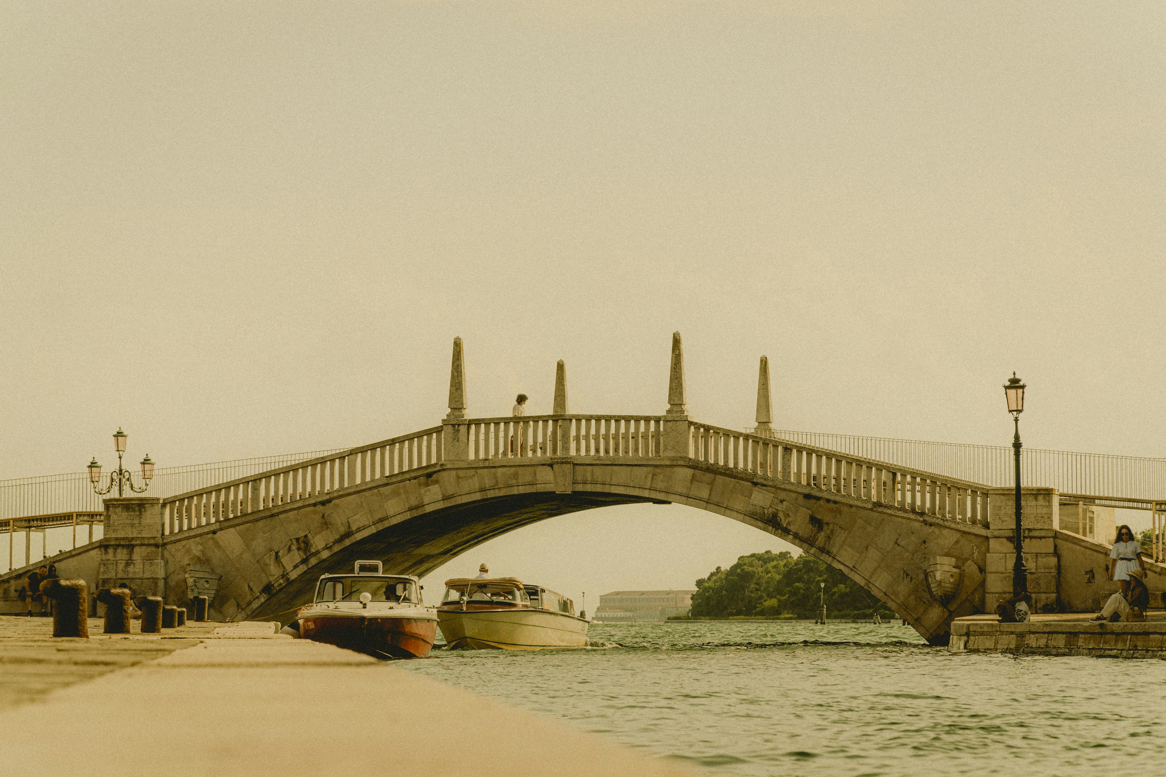 Dusk-lit Sepia Arch Over the Canal, Boats Rest Beneath a Timeless Bridge