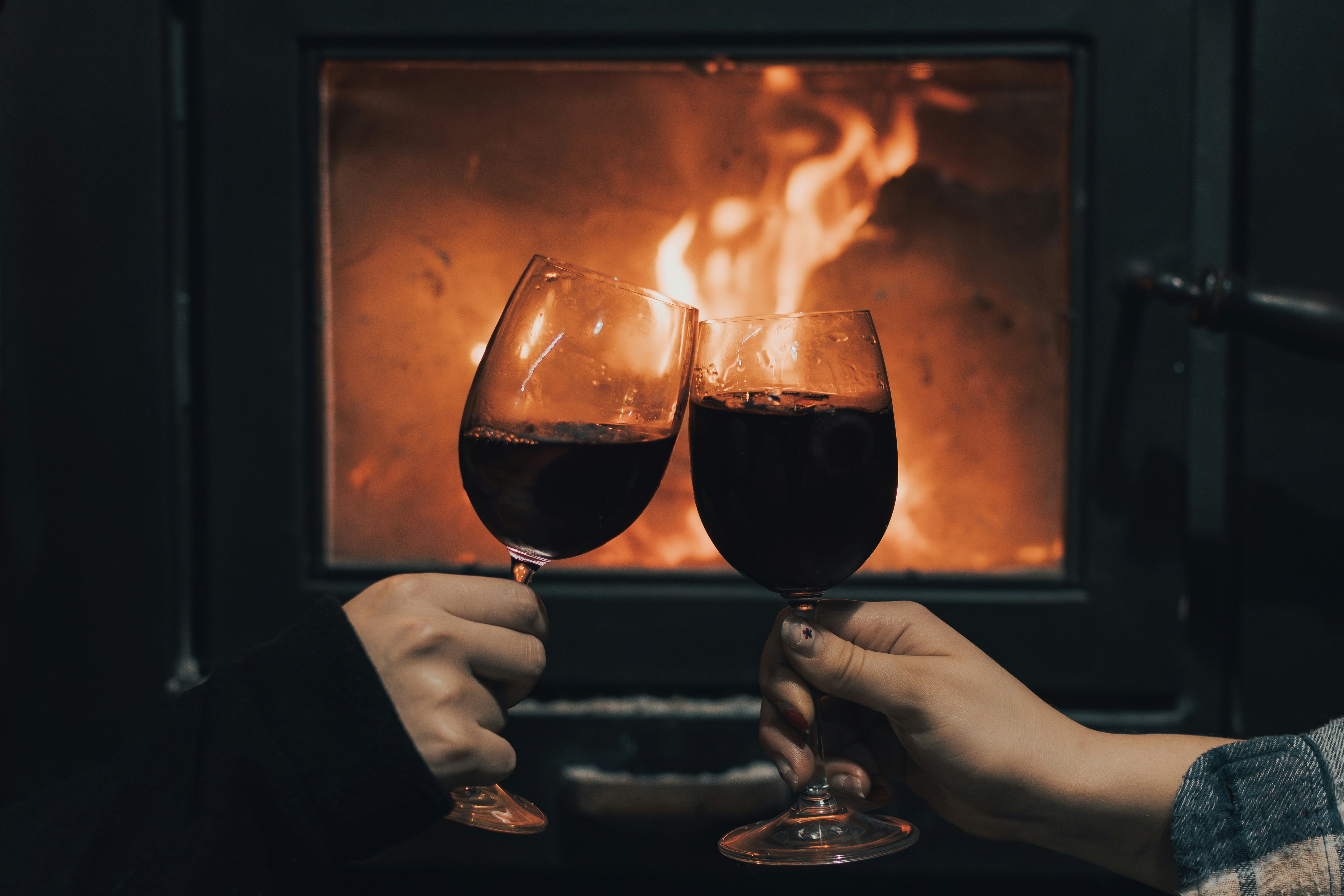 Two people toasting with red wine in front of a fireplace photo – Free ...