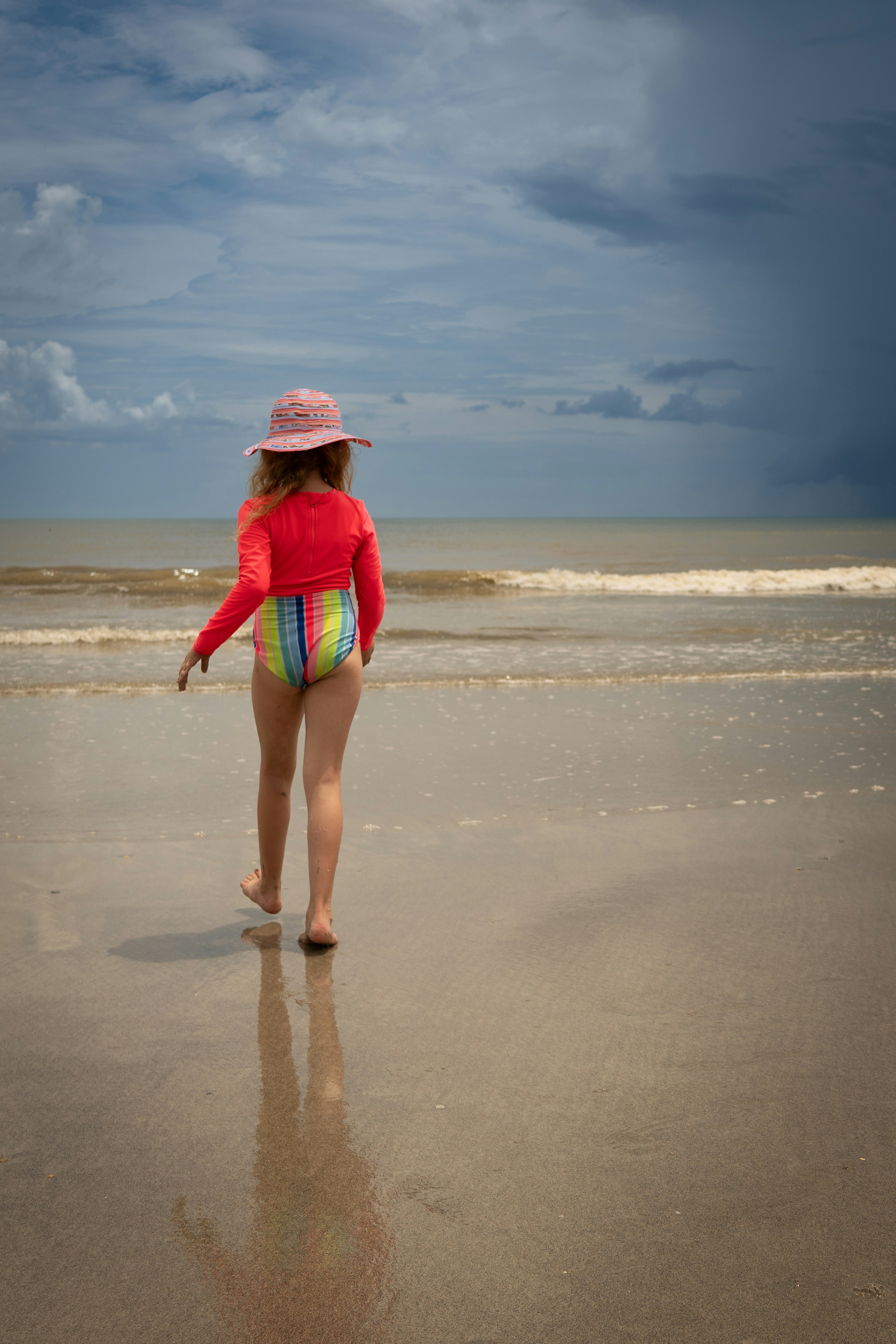 Stride Toward the Quiet Tide: A girl in color on the sunlit shore