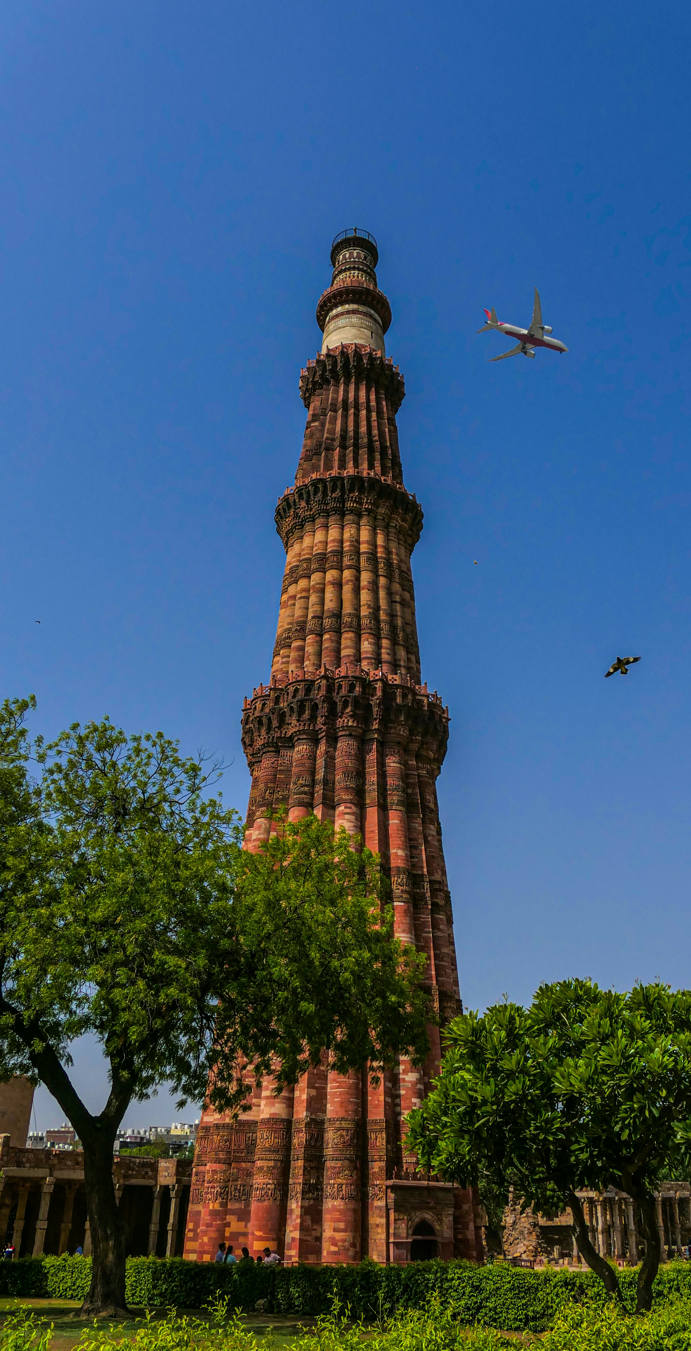 a plane is flying over a tall tower