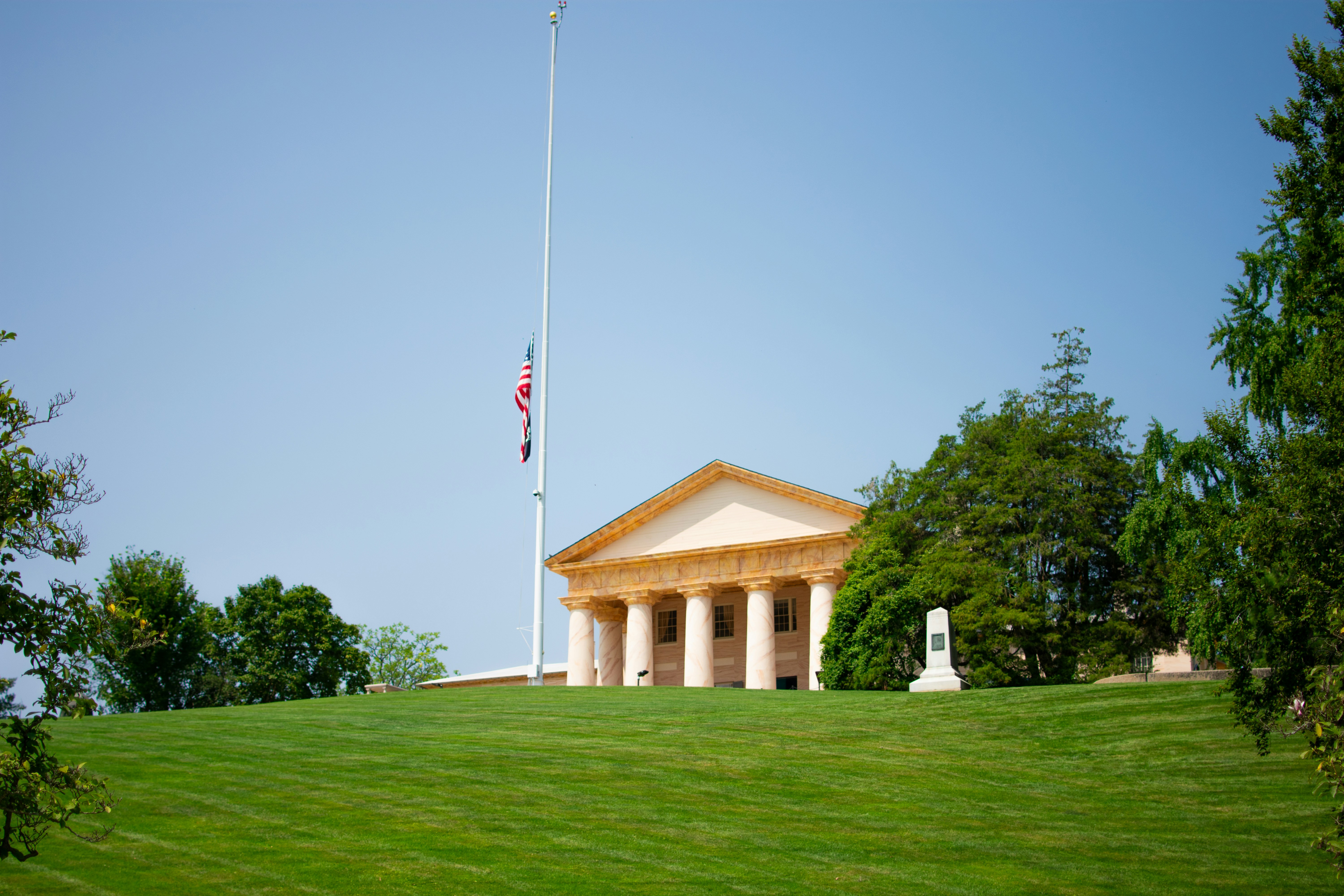 Hilltop Temple: Neoclassical Columns Amid a Sunlit Greenscape