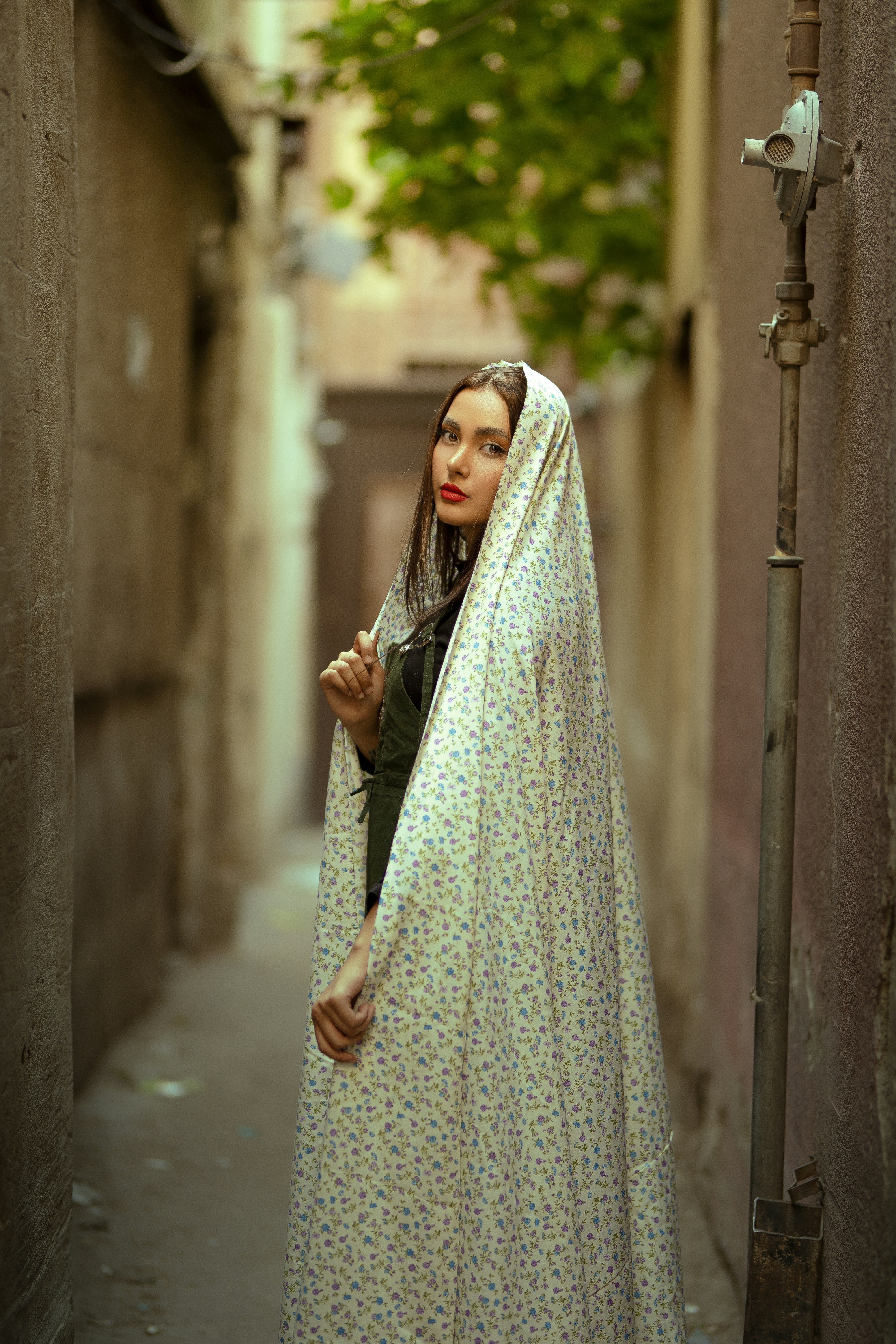 A woman in a white dress is standing in an alley way photo – Free Iran ...