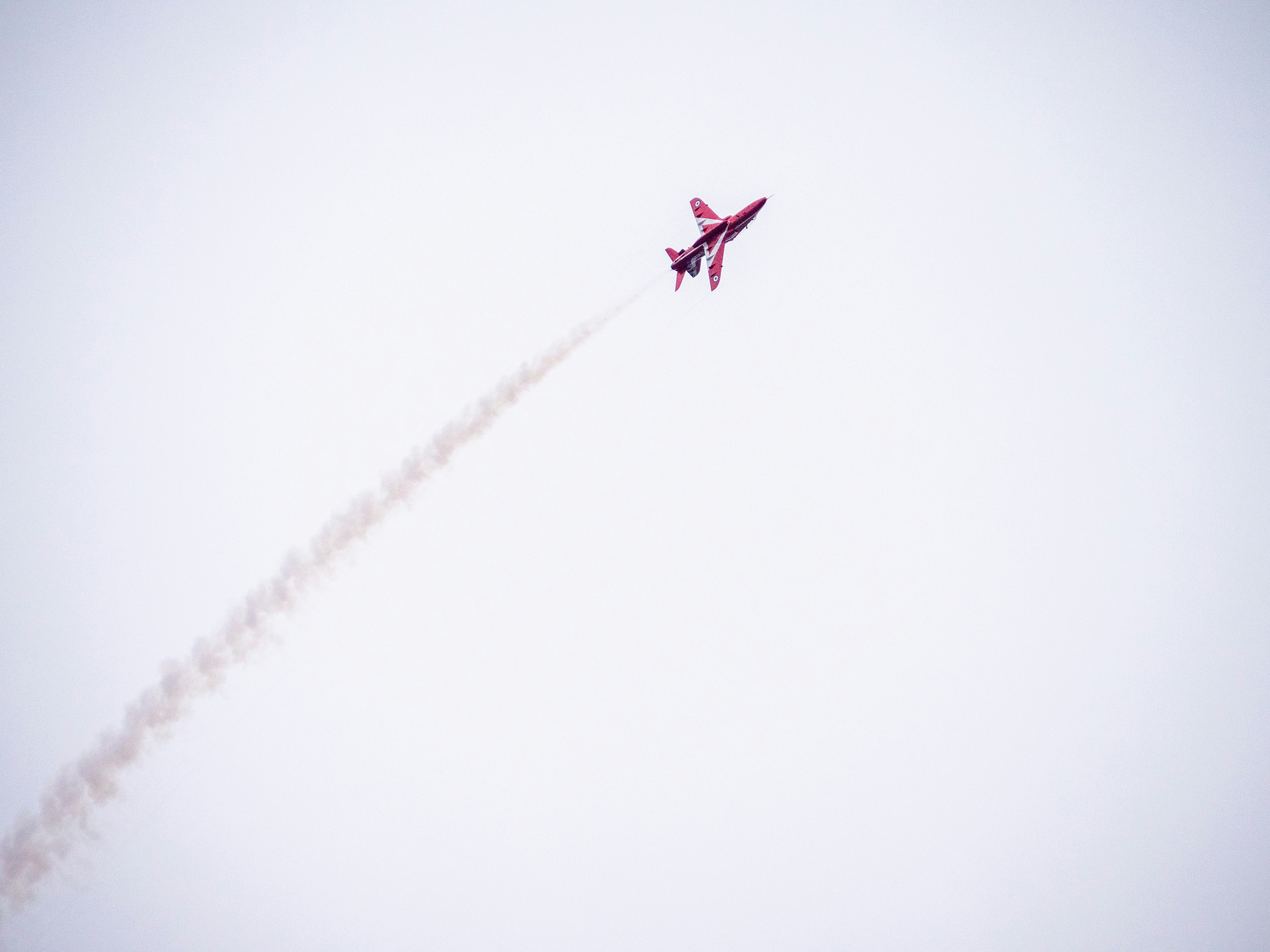 Un avión volando en el cielo dejando un rastro de humo detrás de él ...