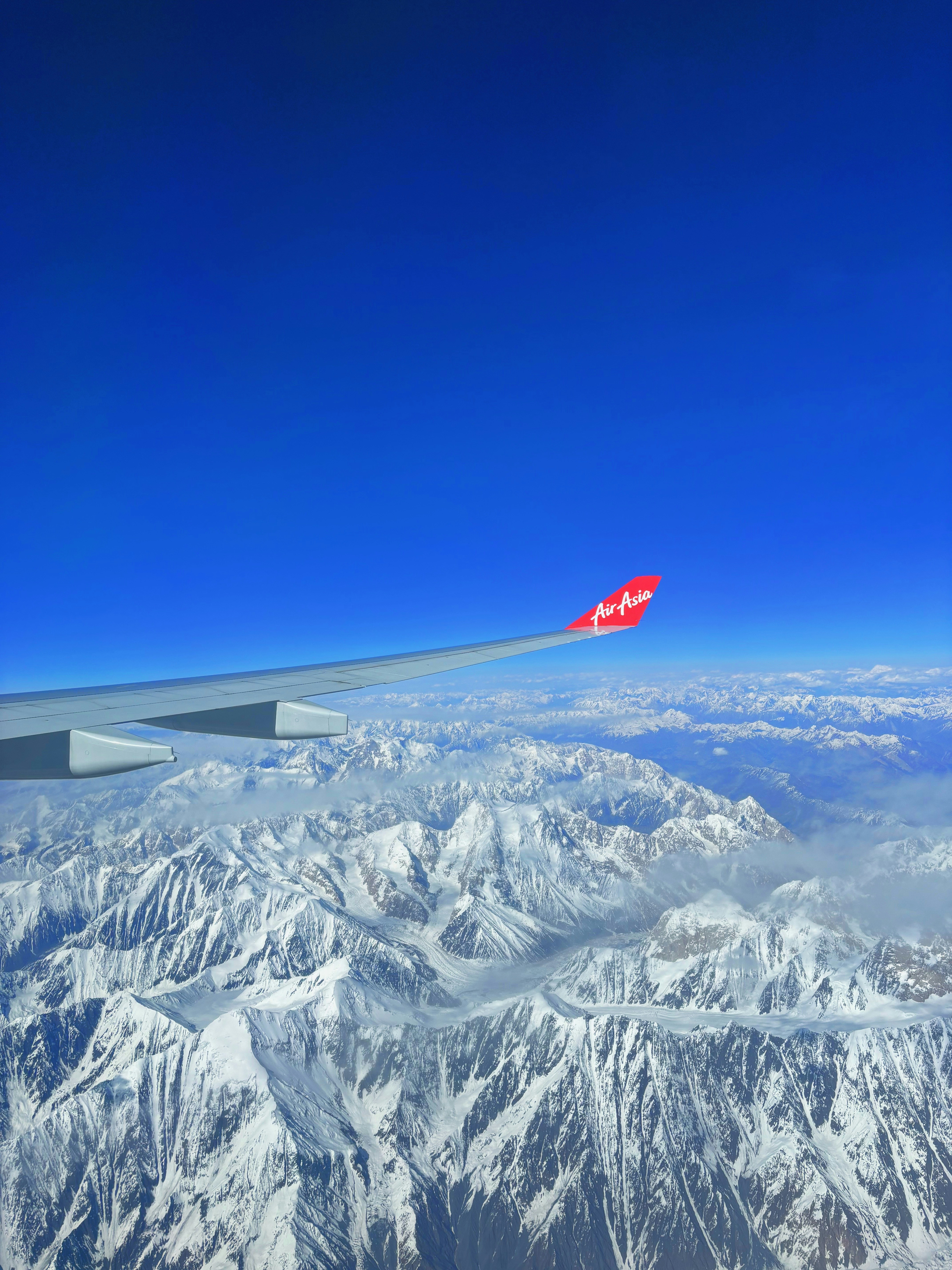 Wingtip over the Alpine sea: AirAsia glides above snow-kissed peaks