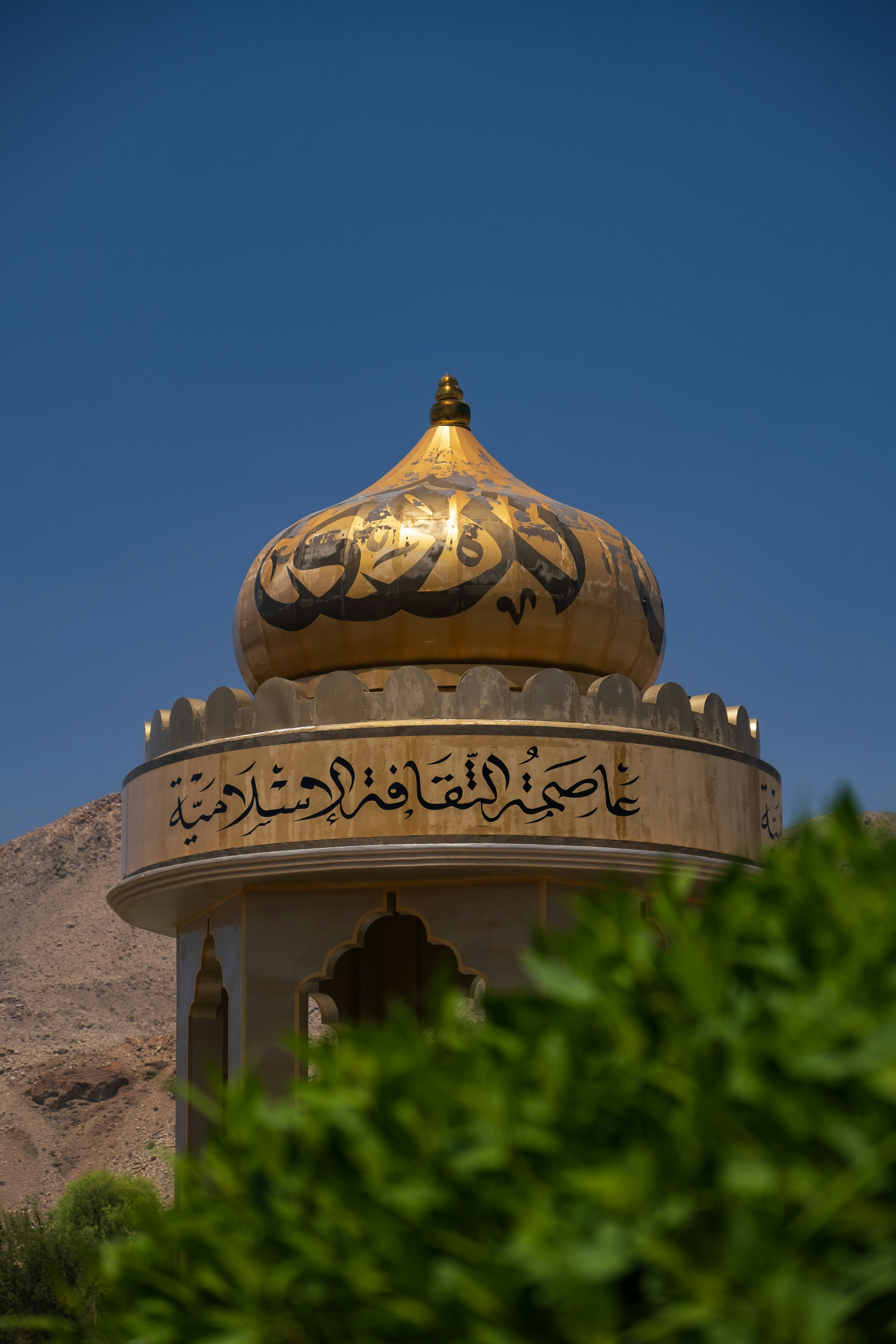a golden dome with arabic writing on it