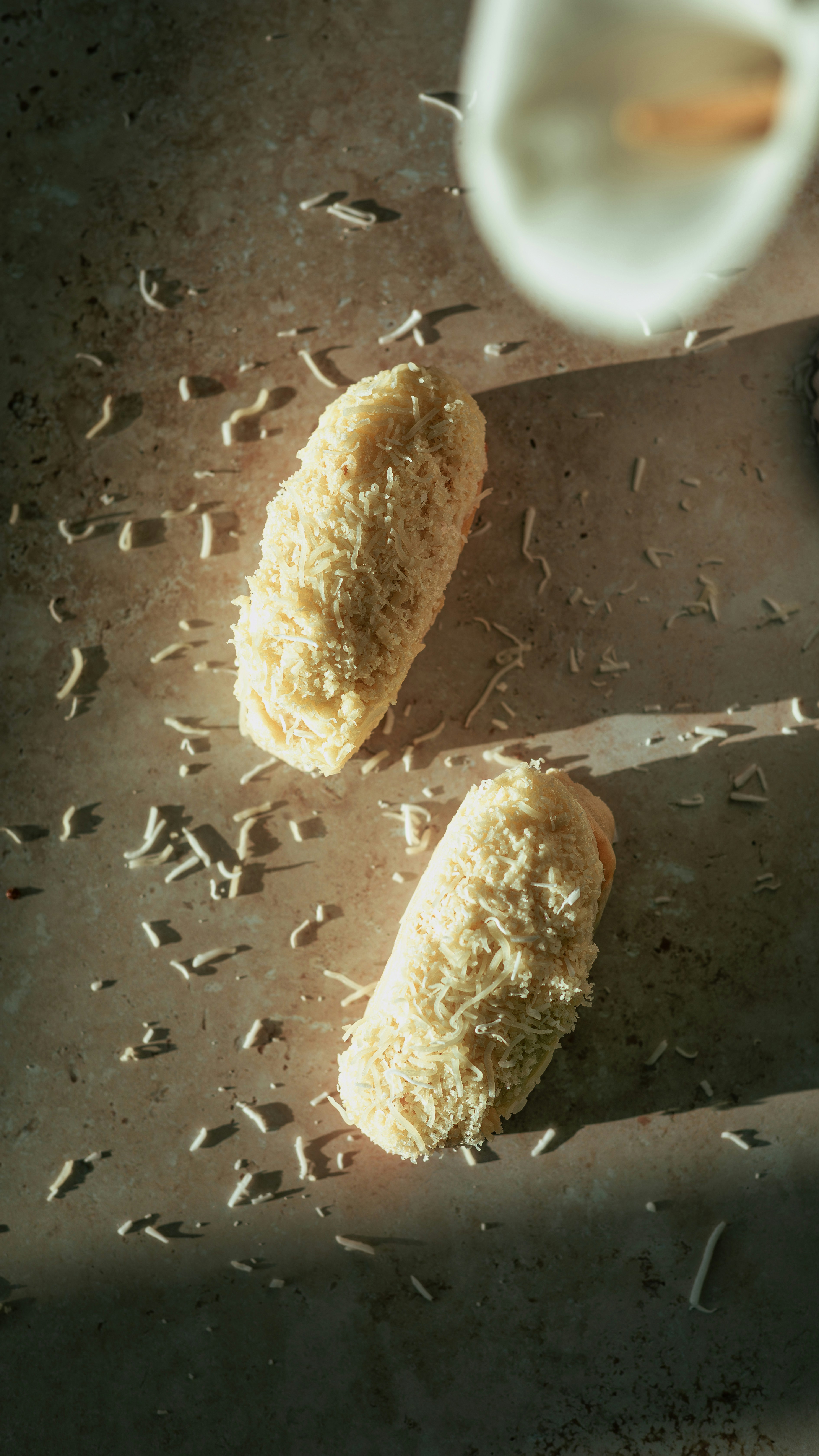 Sunlit crumb-coated croquettes on a seasoned baking sheet
