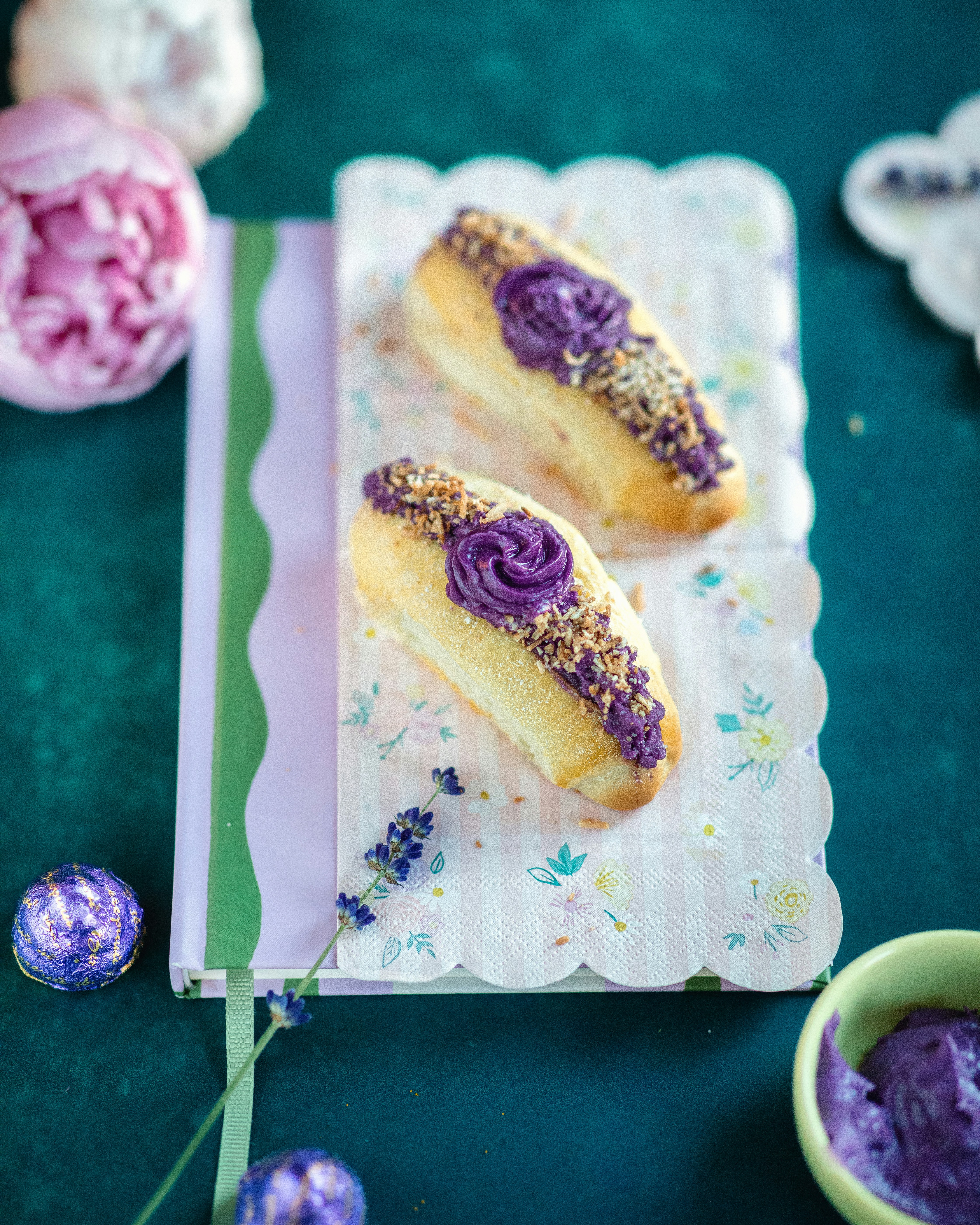Two pastries with purple icing and sprinkles on a paper towel photo ...