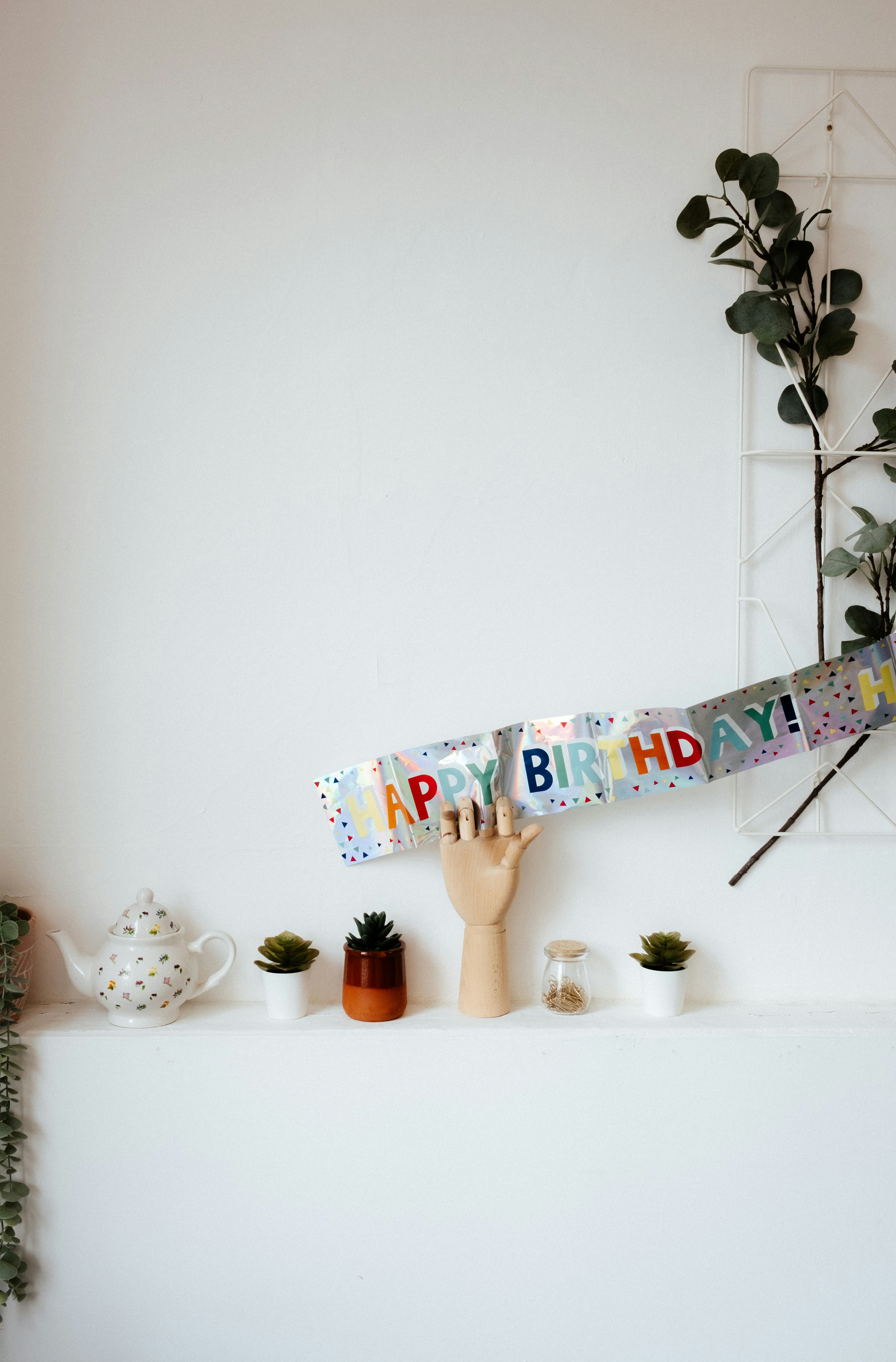 A hand holding a happy birthday banner over a shelf photo – Free Grey ...