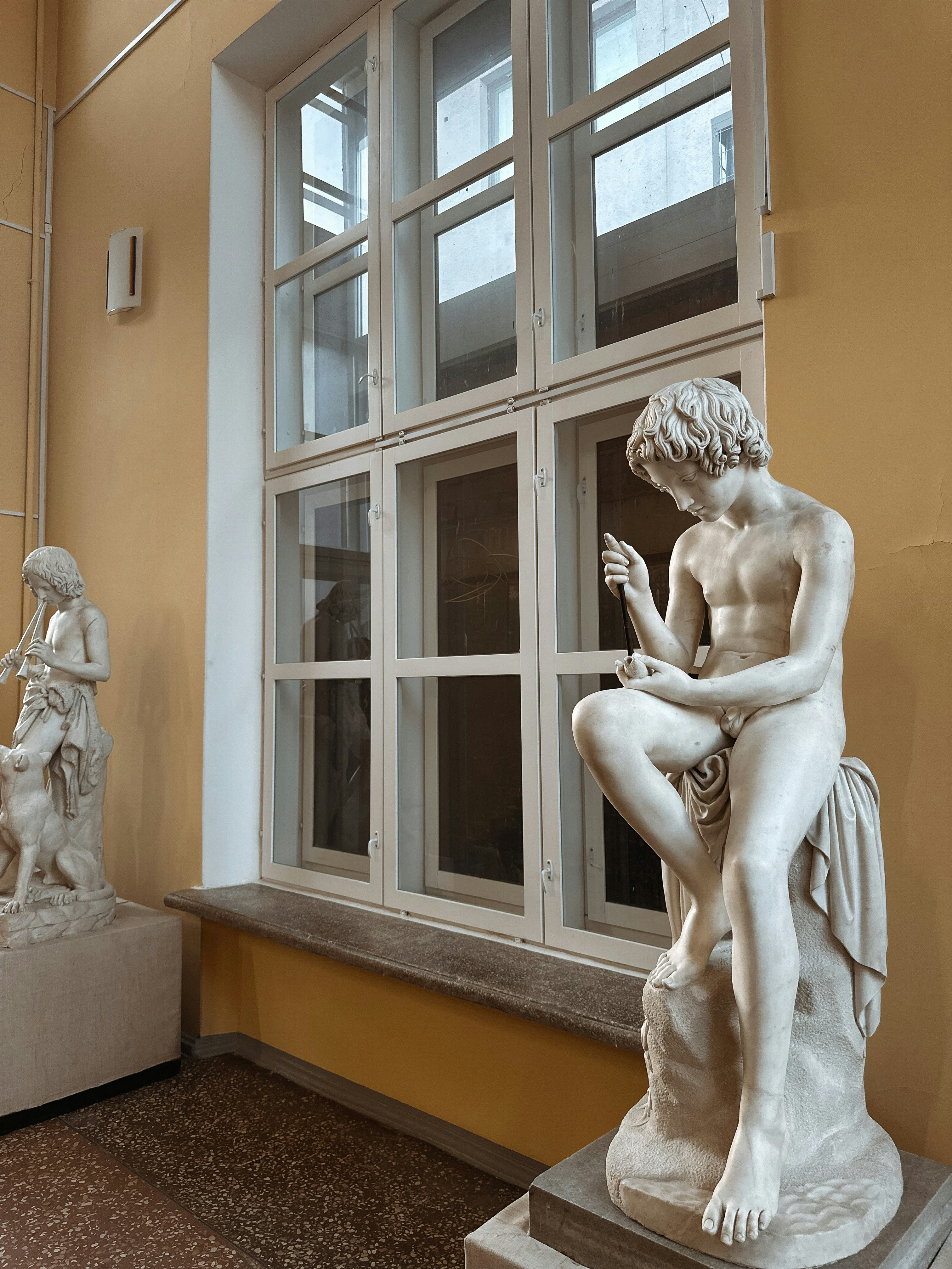 Sunlit Reverie: Marble Statues Beside a Paned Window