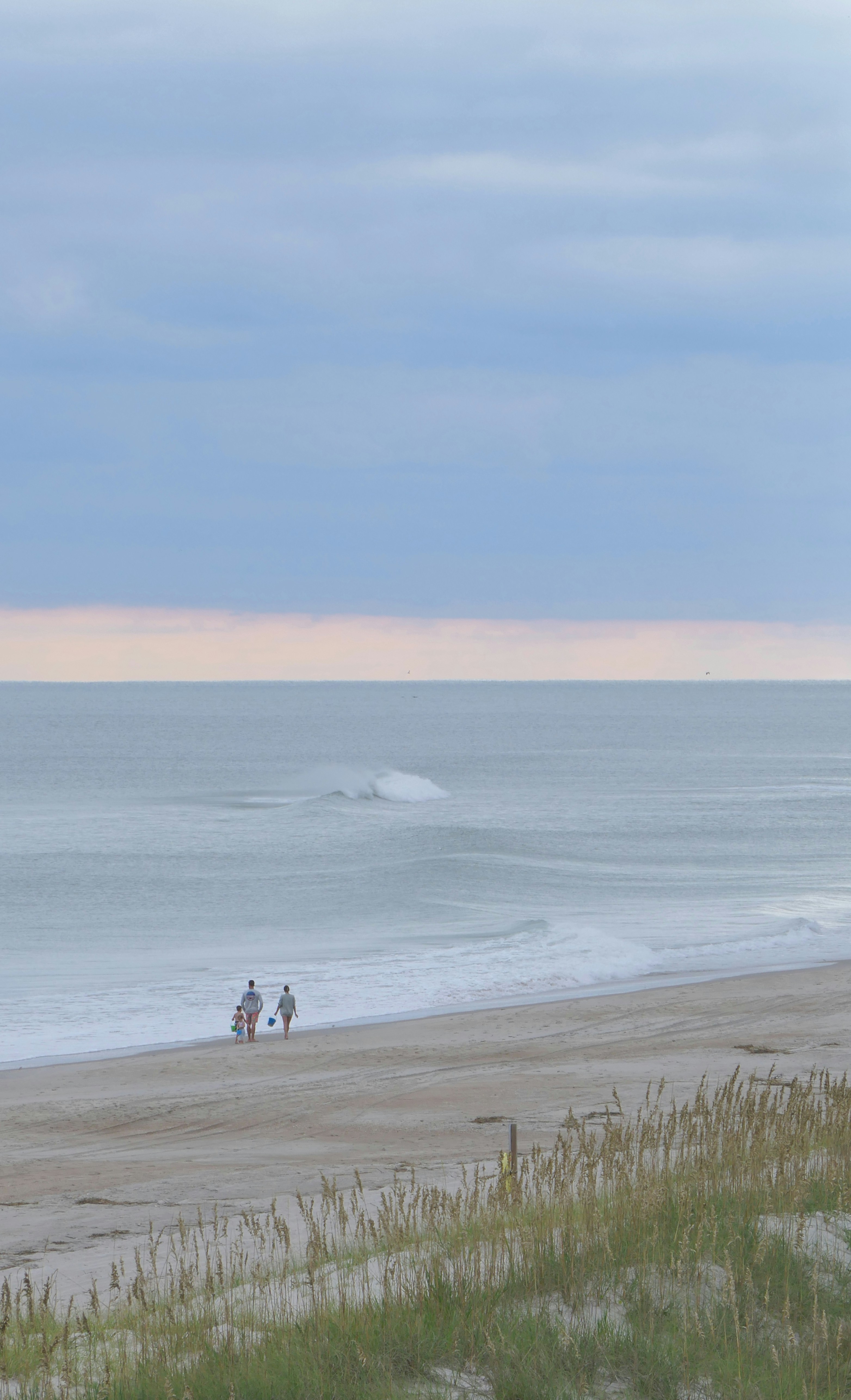 Edge of Calm: Two Beachgoers Along a Quiet Horizon