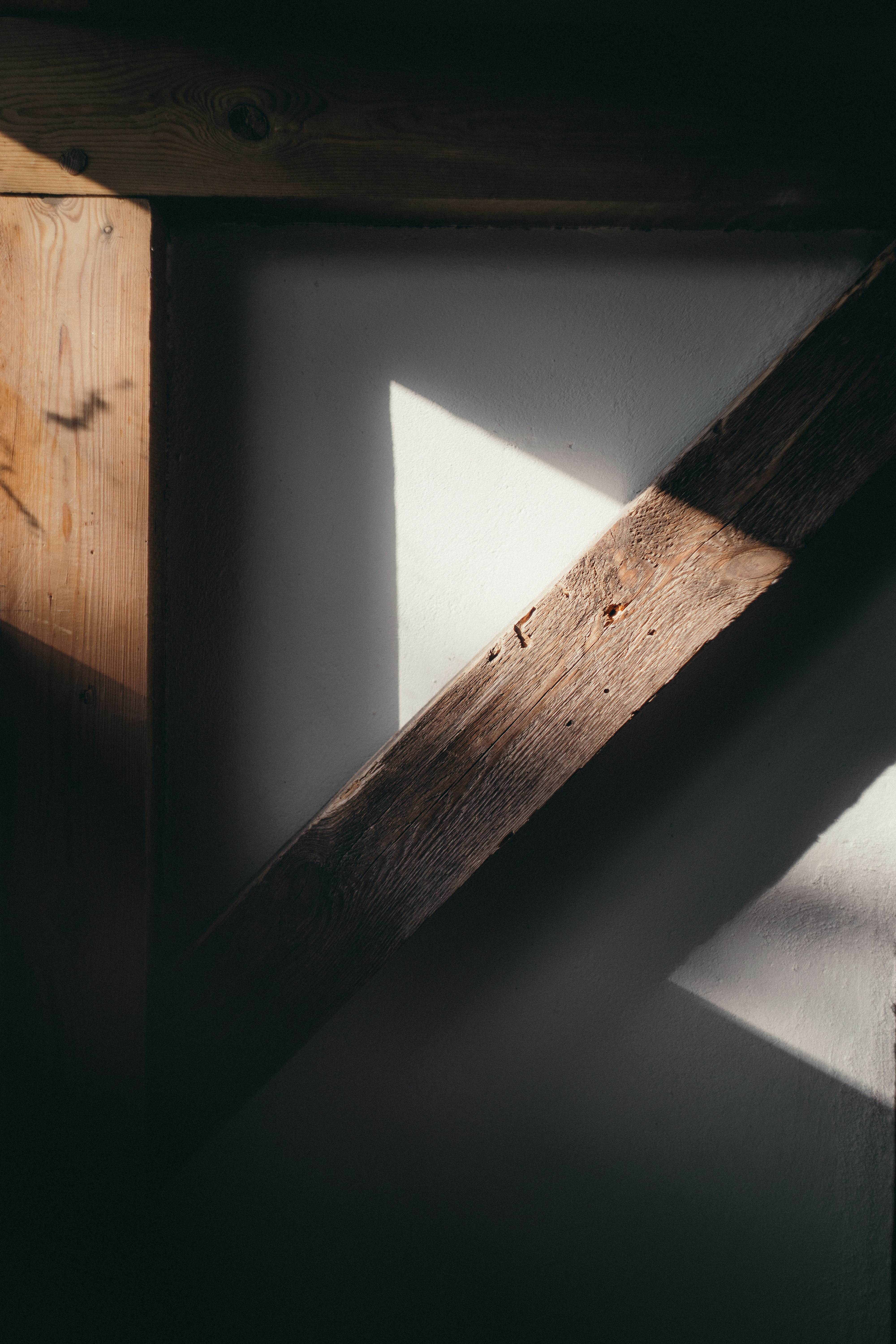 Geometric Quiet: Sunlit Triangle Among Weathered Beams