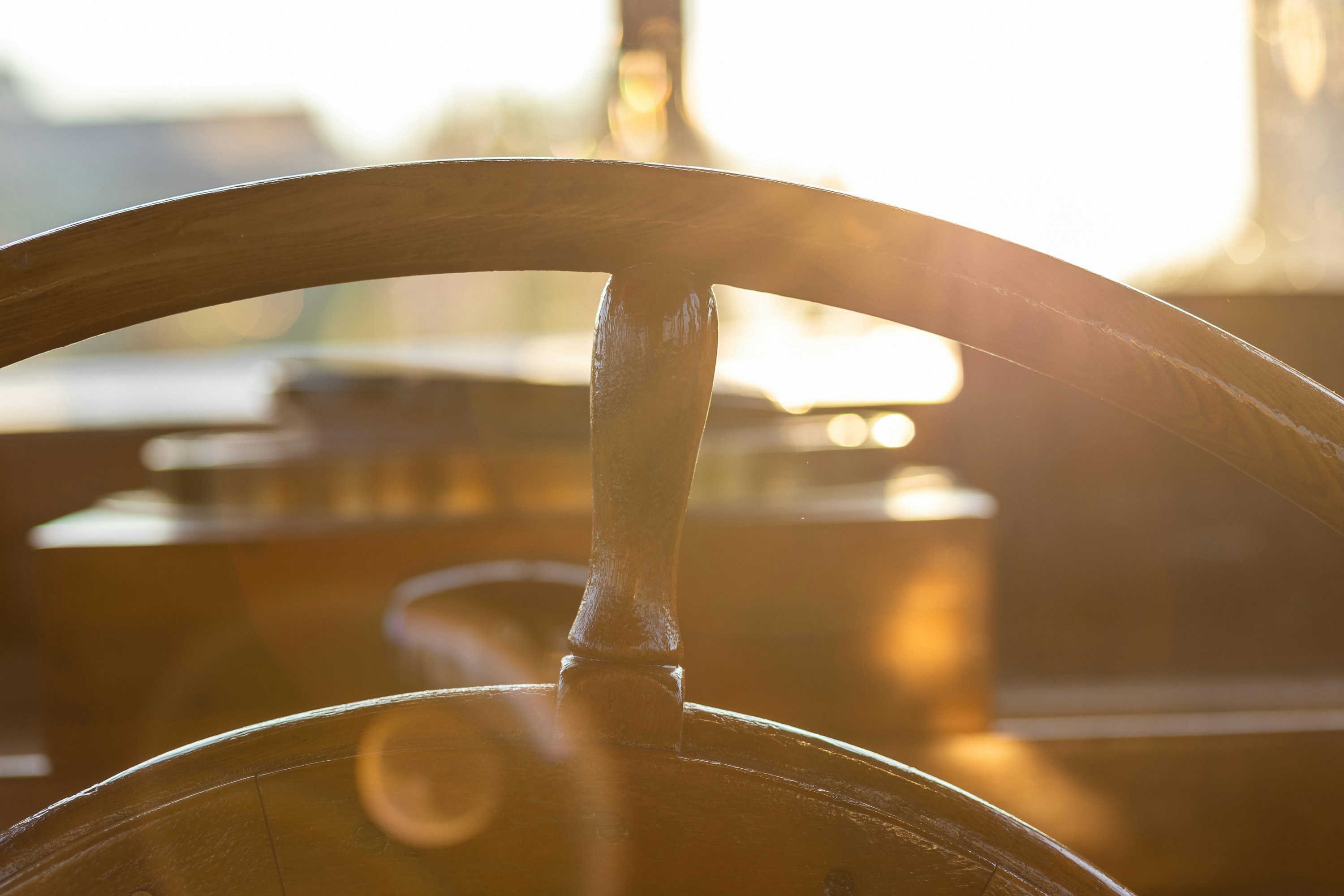 Golden Hour on a Vintage Ship Wheel: Close-Up of a Maritime Helm