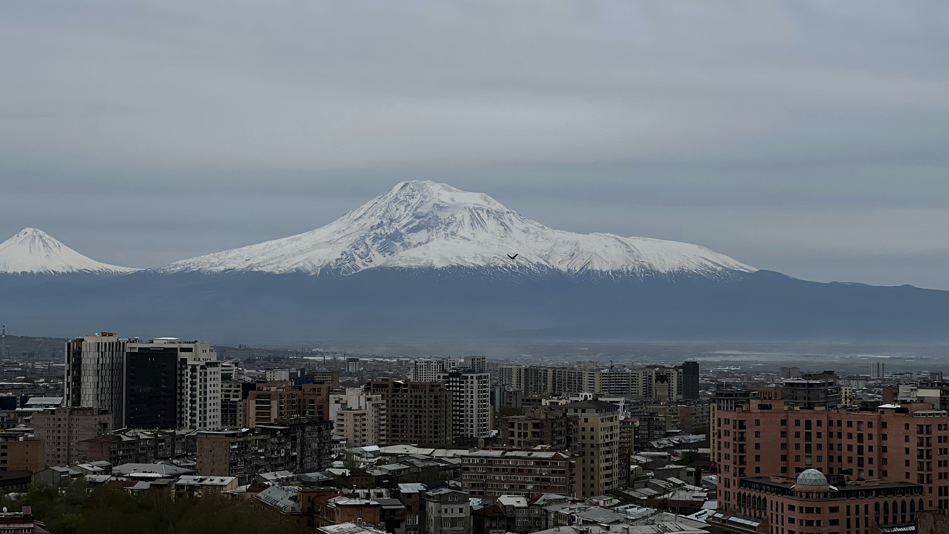 Snowbound Peaks Loom Over a Quiet Cityscape