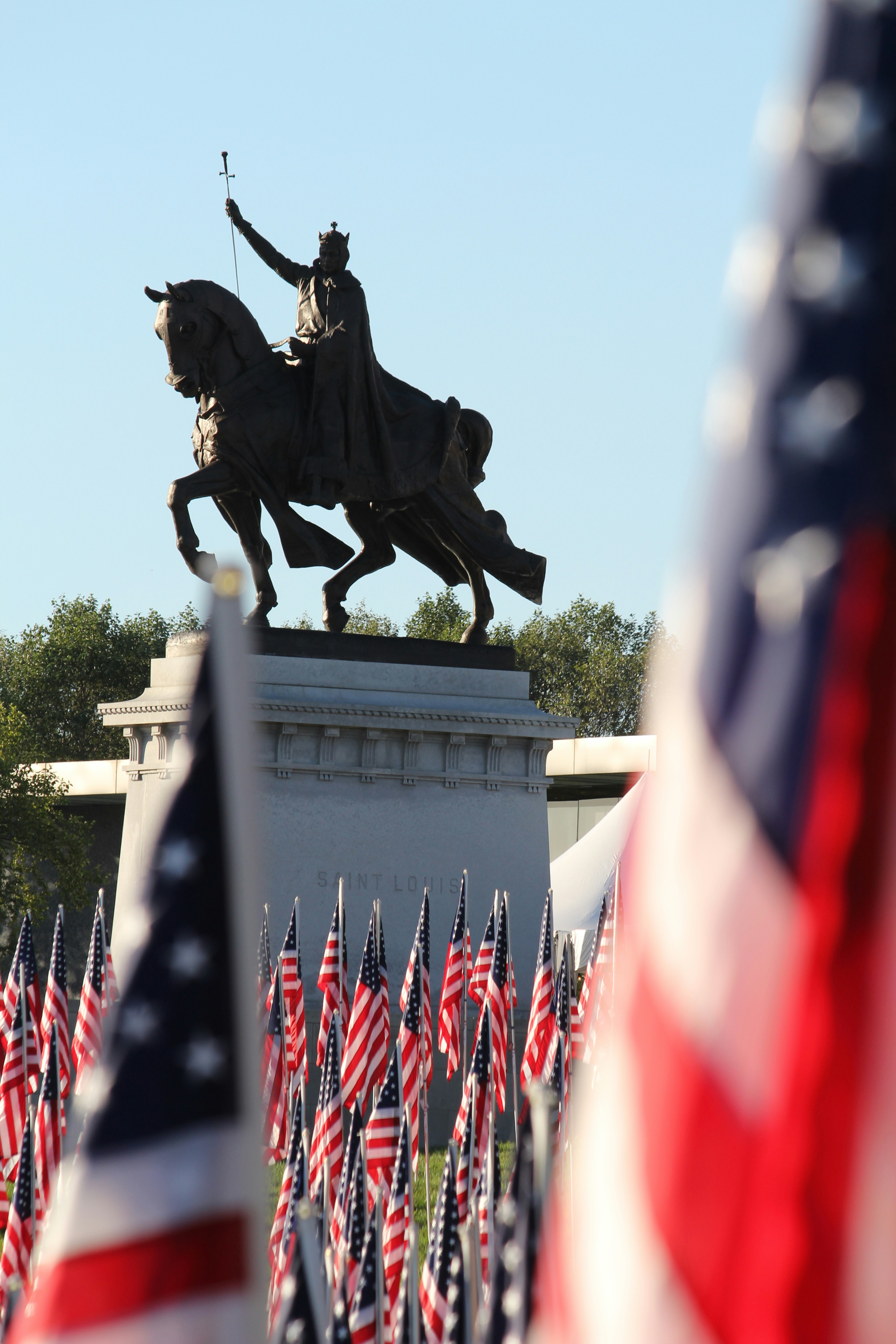 A statue of a man on a horse surrounded by american flags photo – Free ...