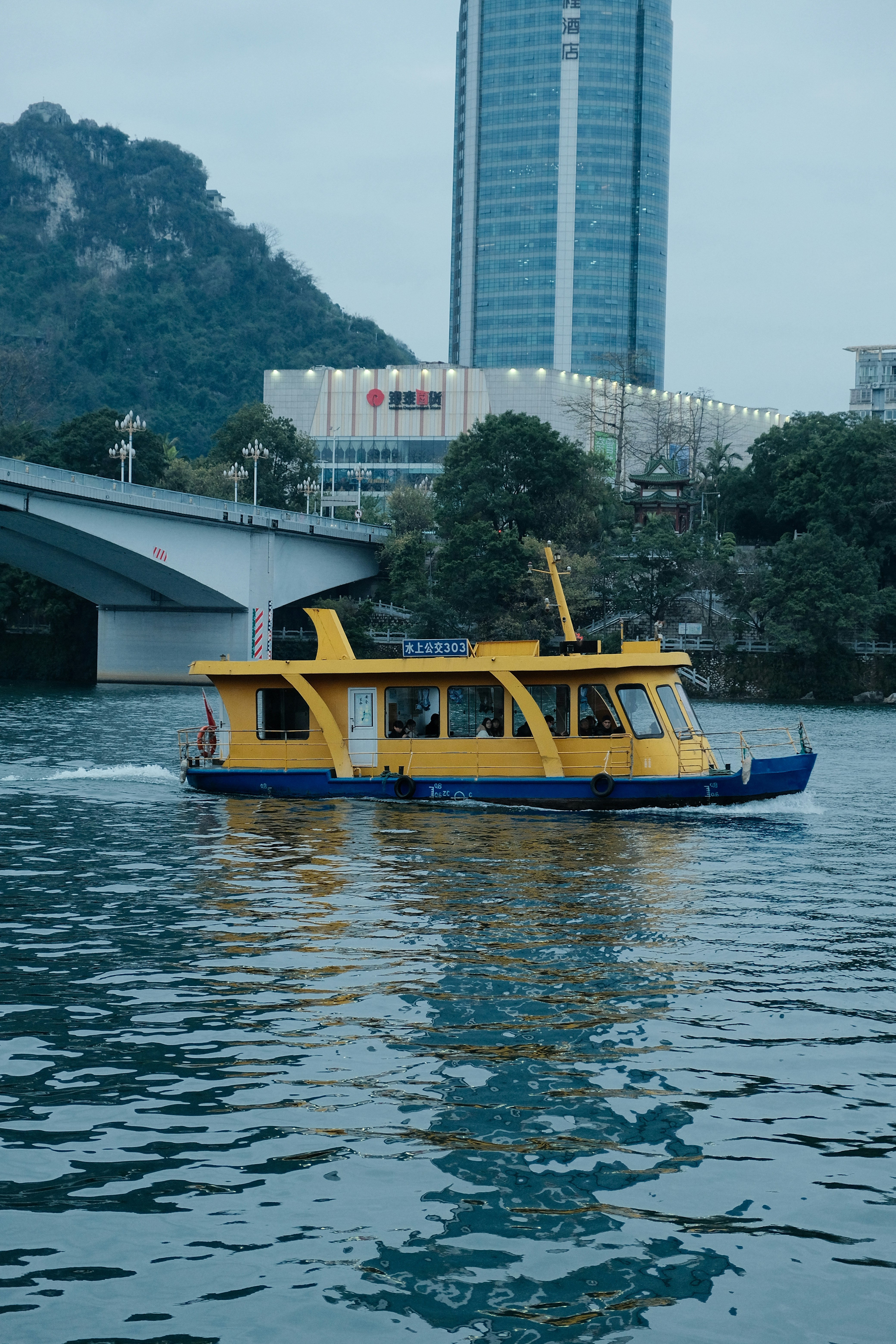 Yellow Passenger Ferry Slicing Through a Riverside Cityscape