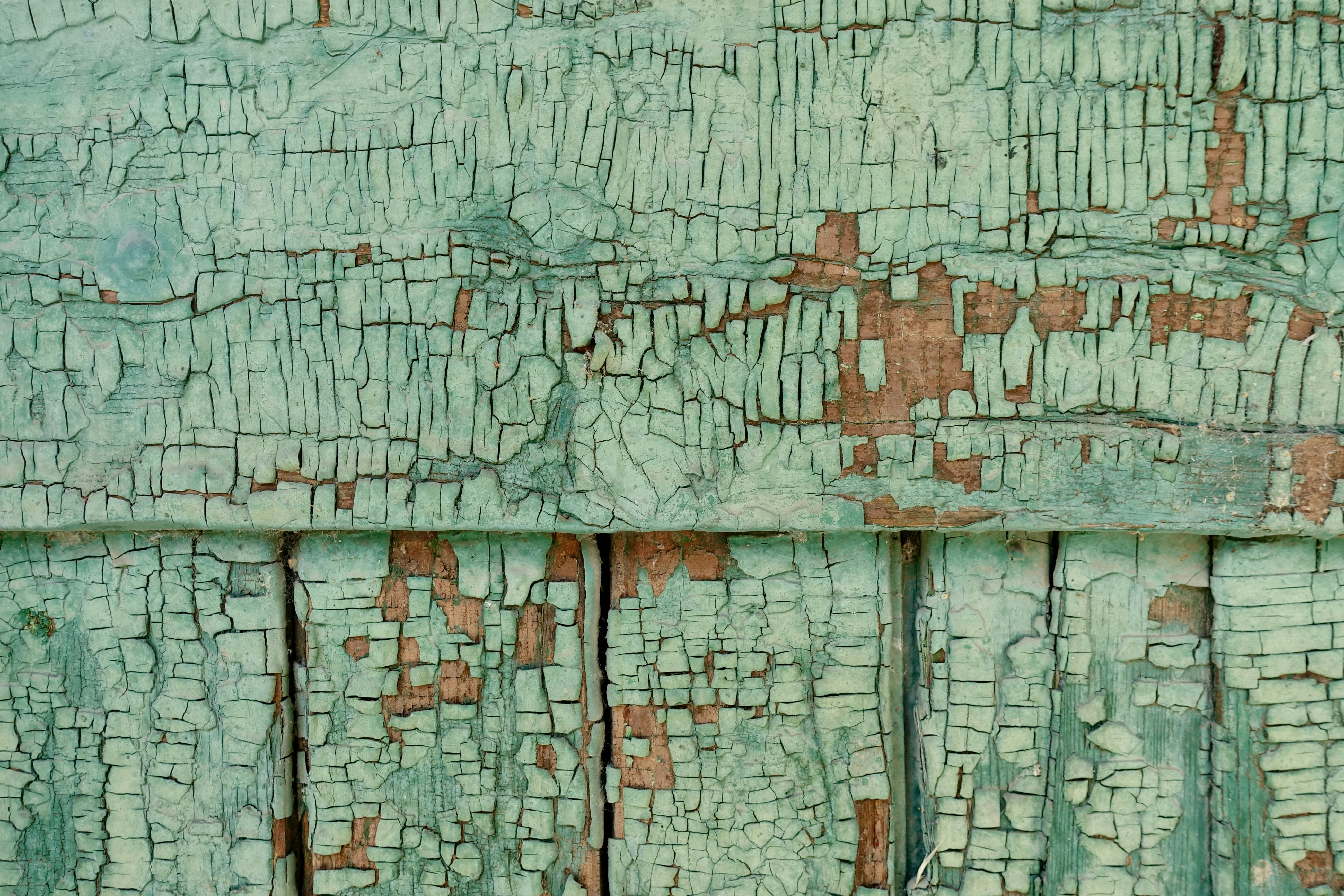 a close up of a wooden wall with peeling paint