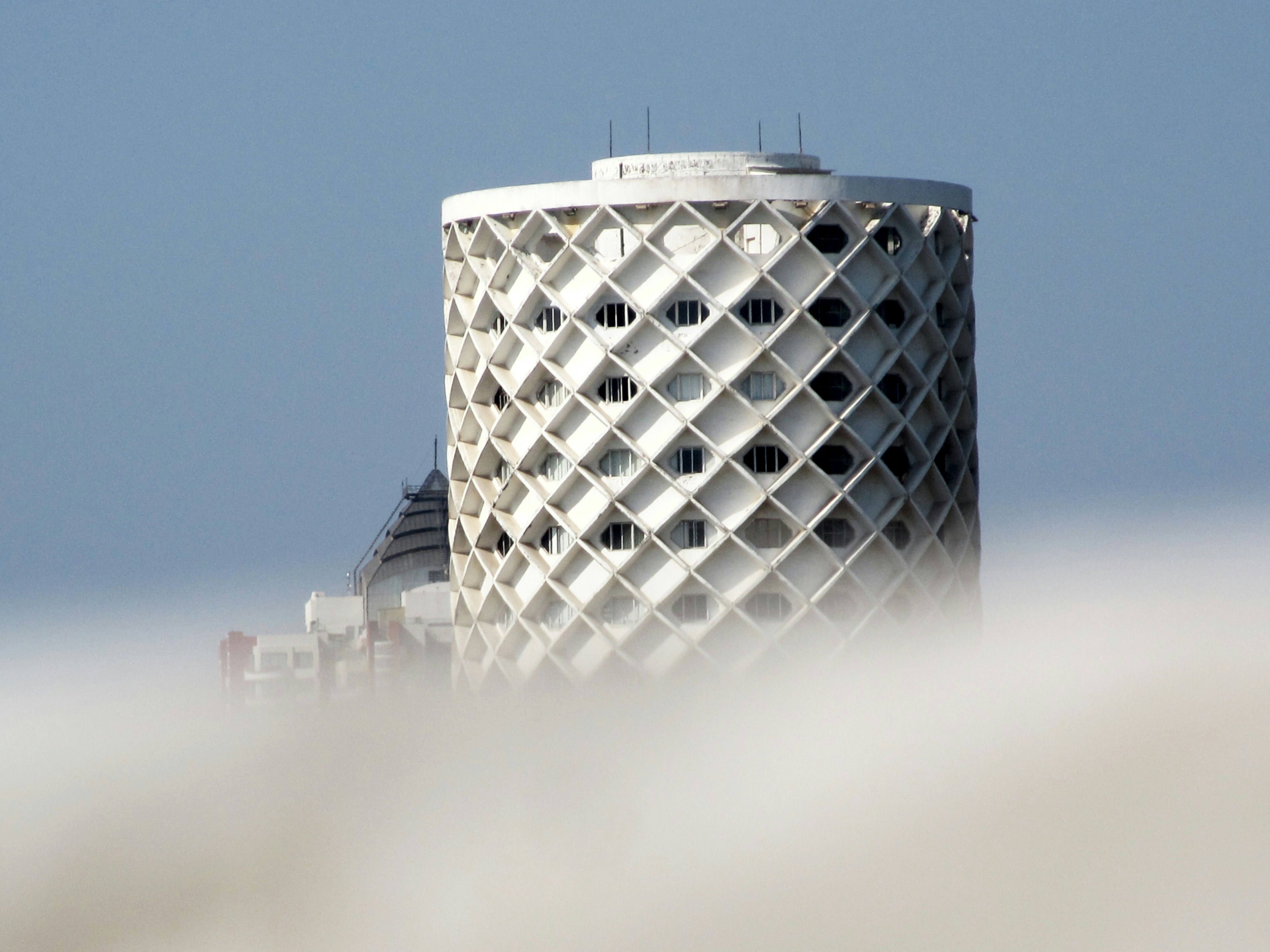 Morning Mist Clings to the Diamond Facade of a City Tower