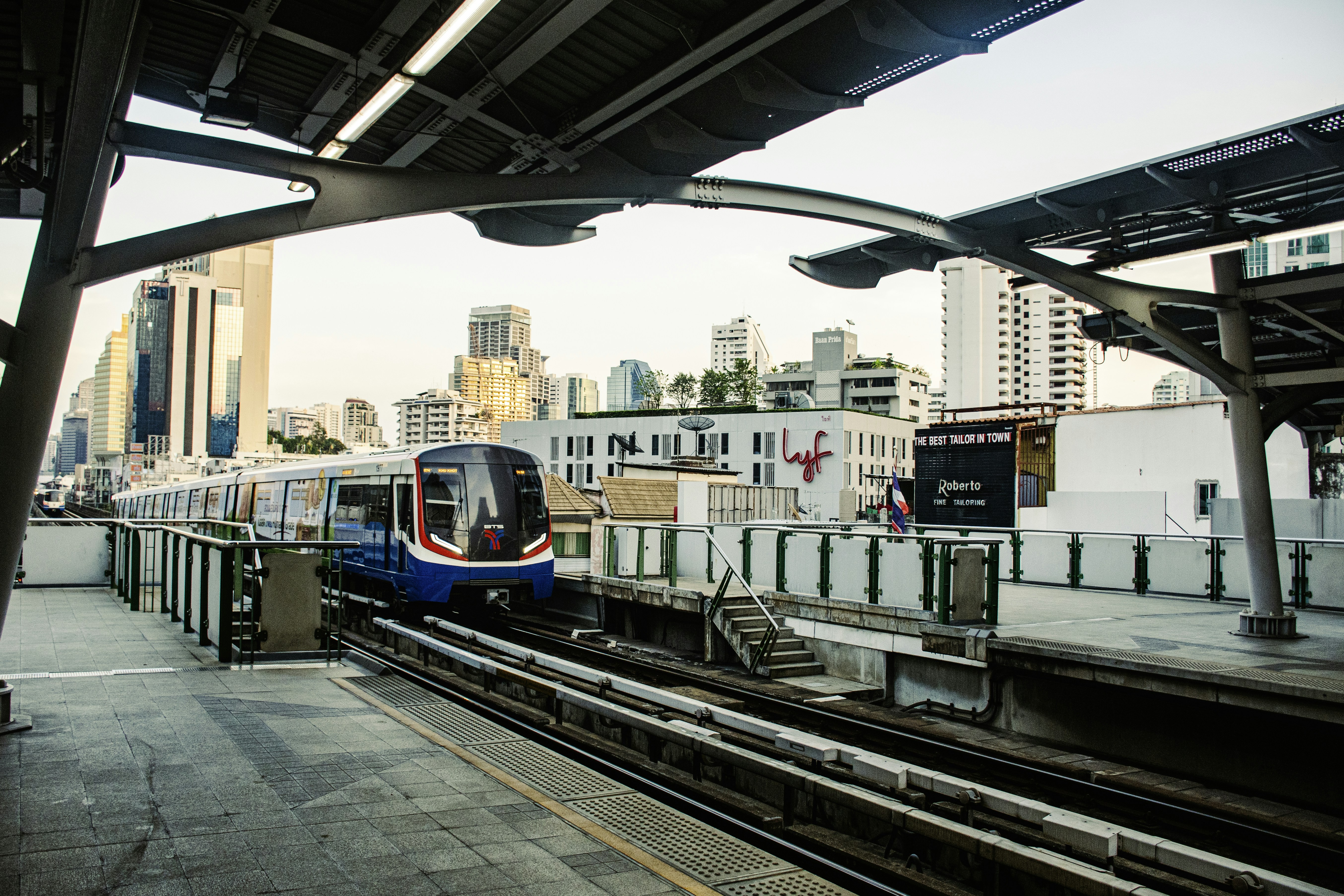 Blue Metro Glide at a Curved-Canopy City Platform