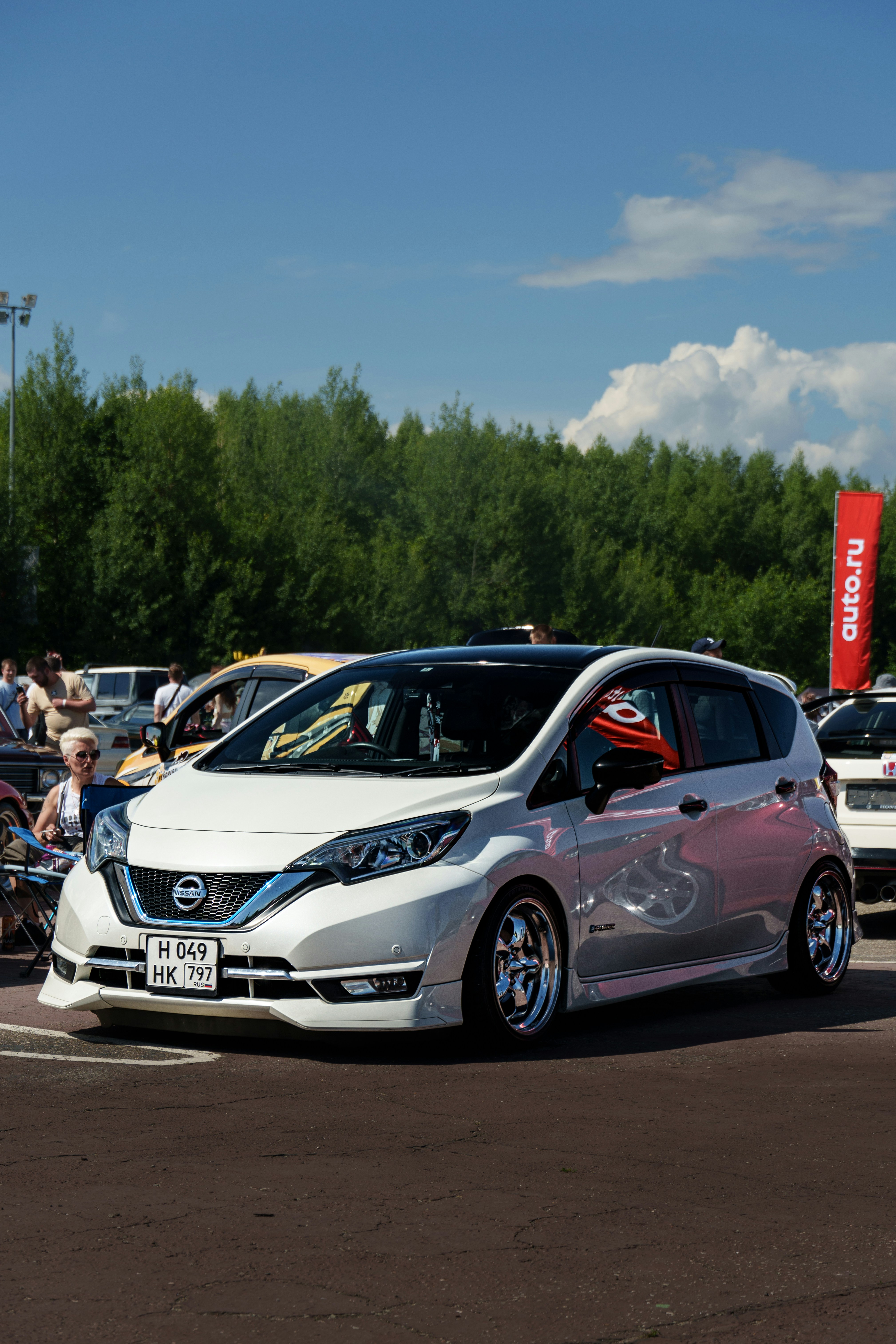 White Nissan Stance at Car Show: Sleek Lines and Shiny Reflections
