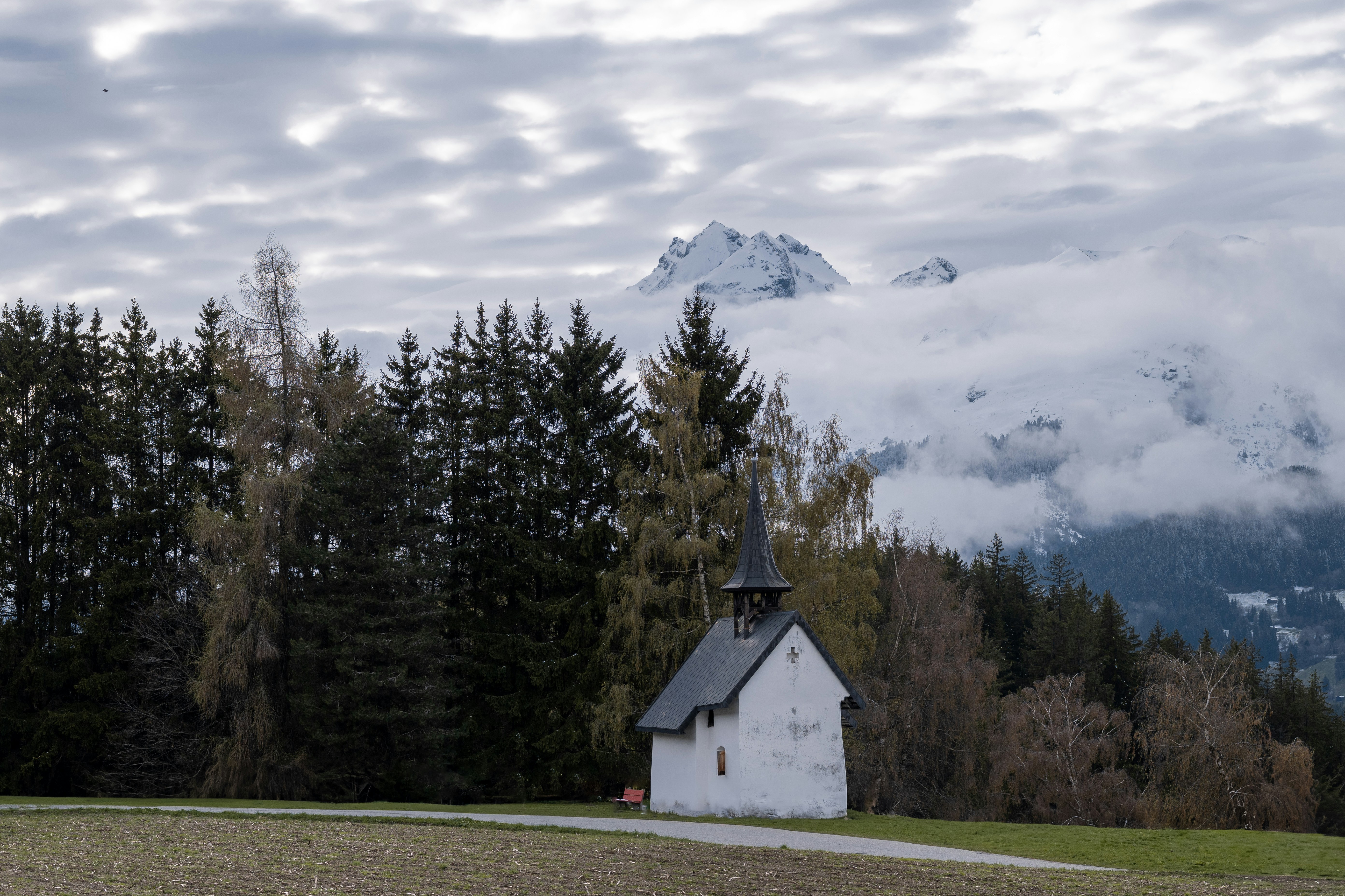 A small white house sitting on top of a lush green field