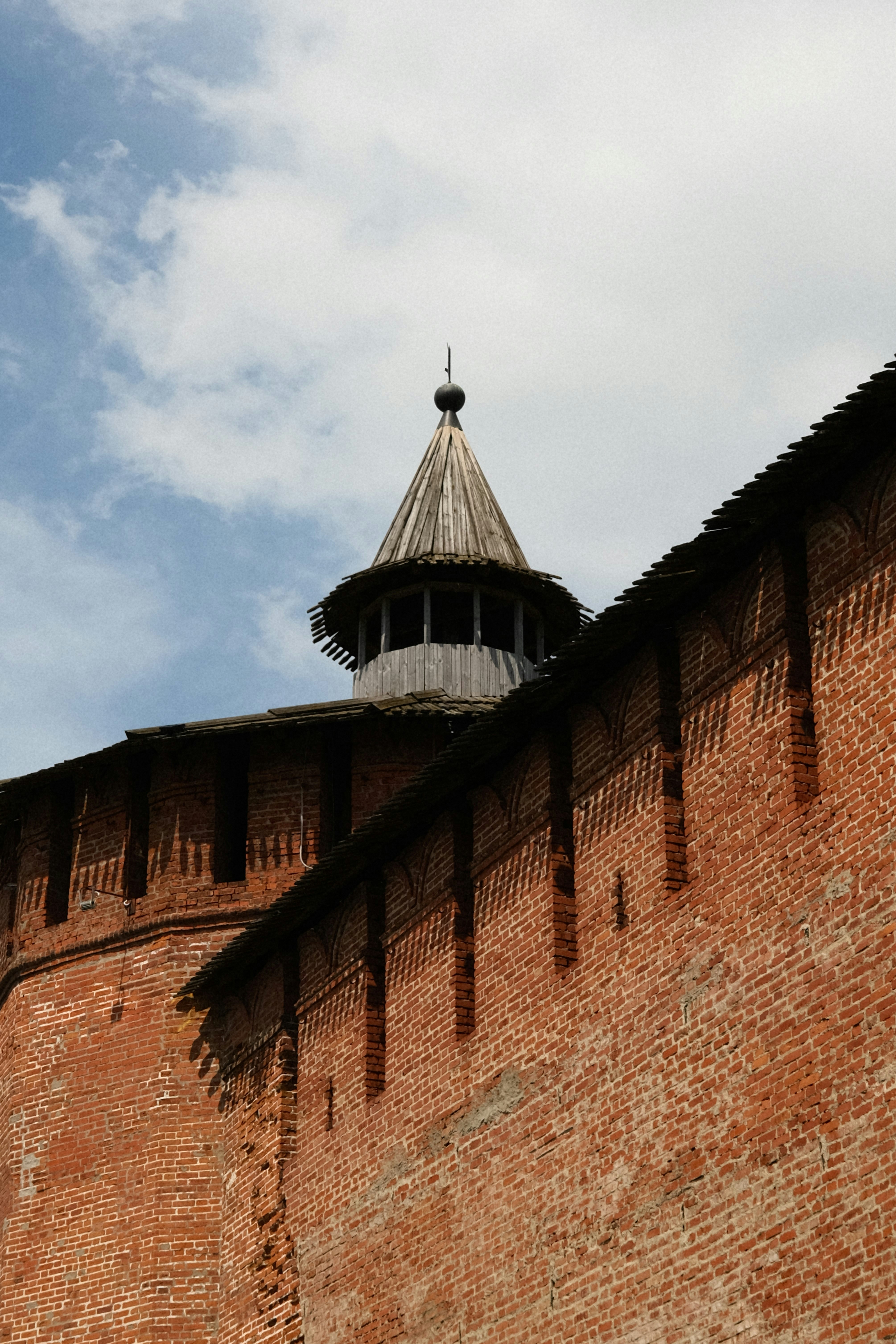 A tall brick wall with a clock tower on top photo – Free Building Image ...