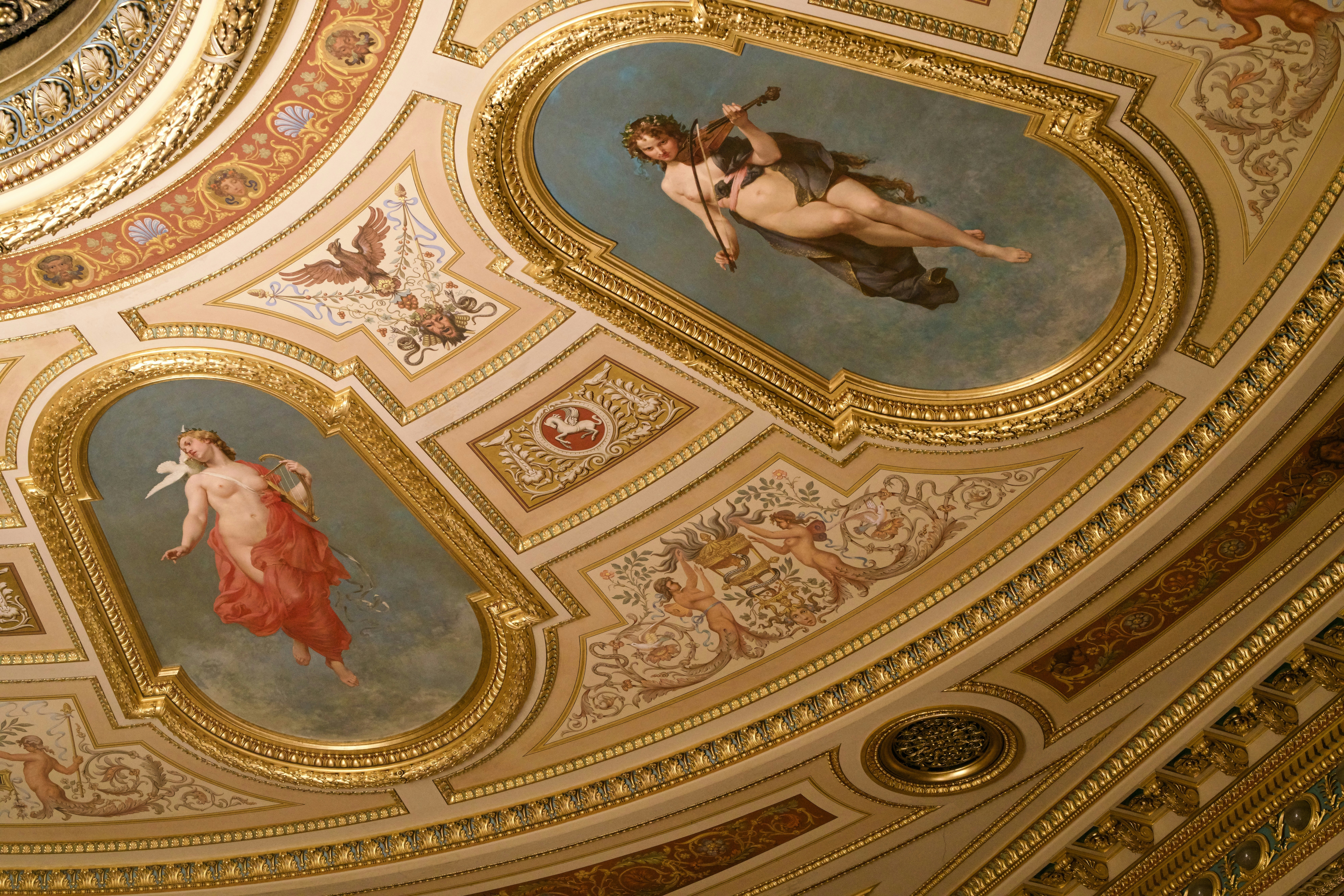 Gold-Crested Frescoes: Two Oval Mythic Portraits Adorning a Palace Ceiling