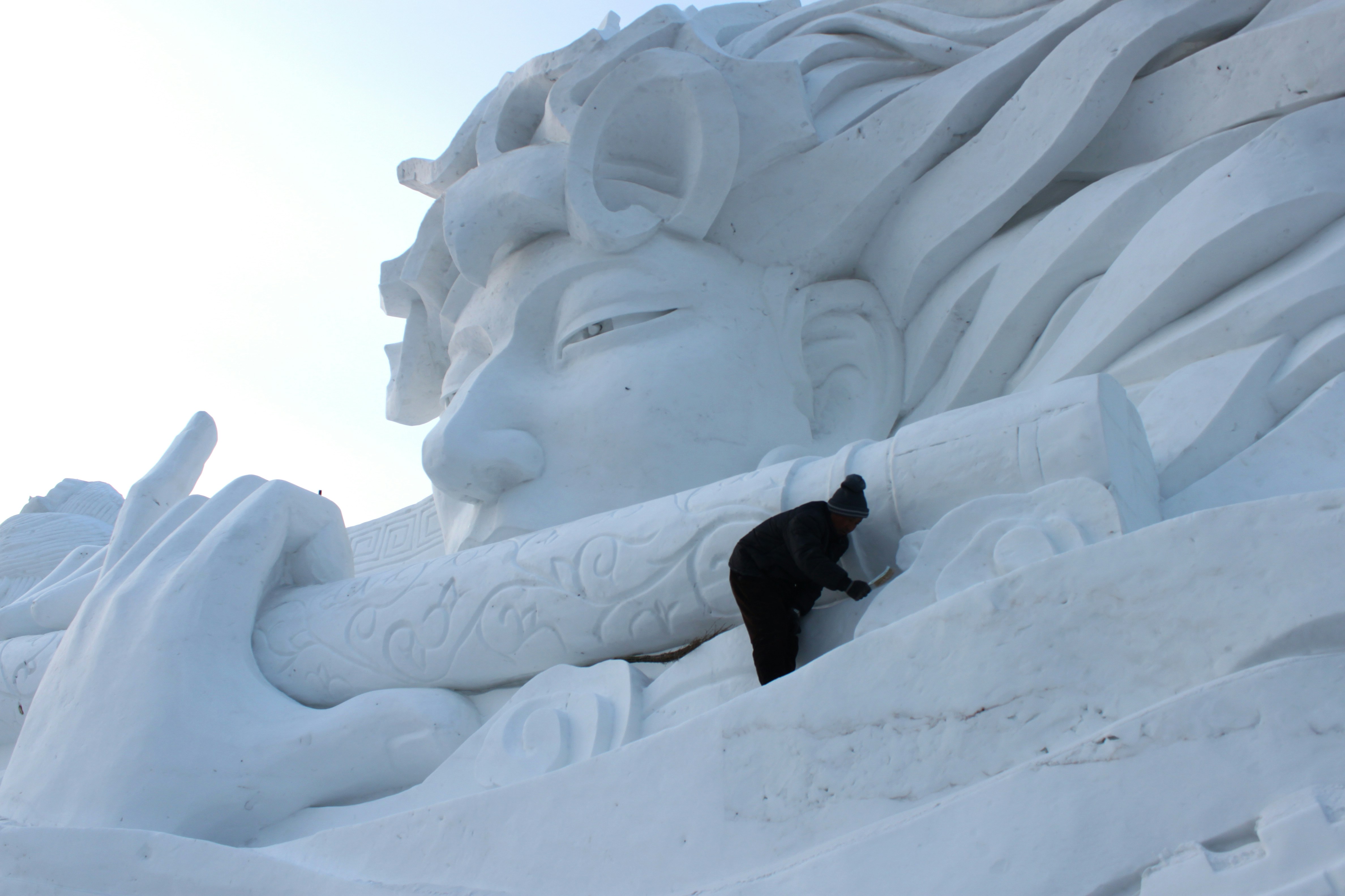 Climber on the Frozen Portrait: Scaling a Giant Snow Sculpture