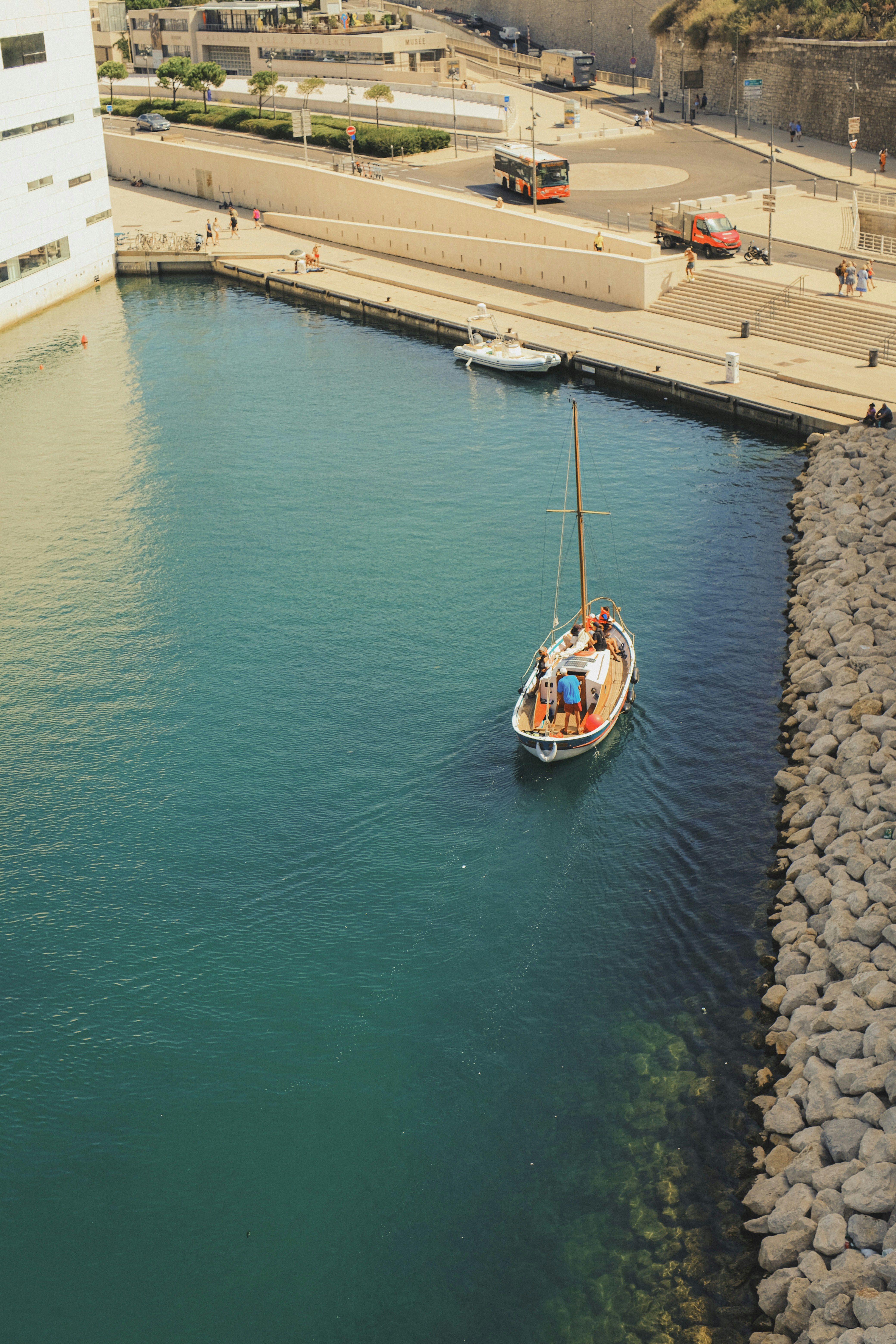 Turquoise Channel: A Sailboat Drifts Toward the Promenade