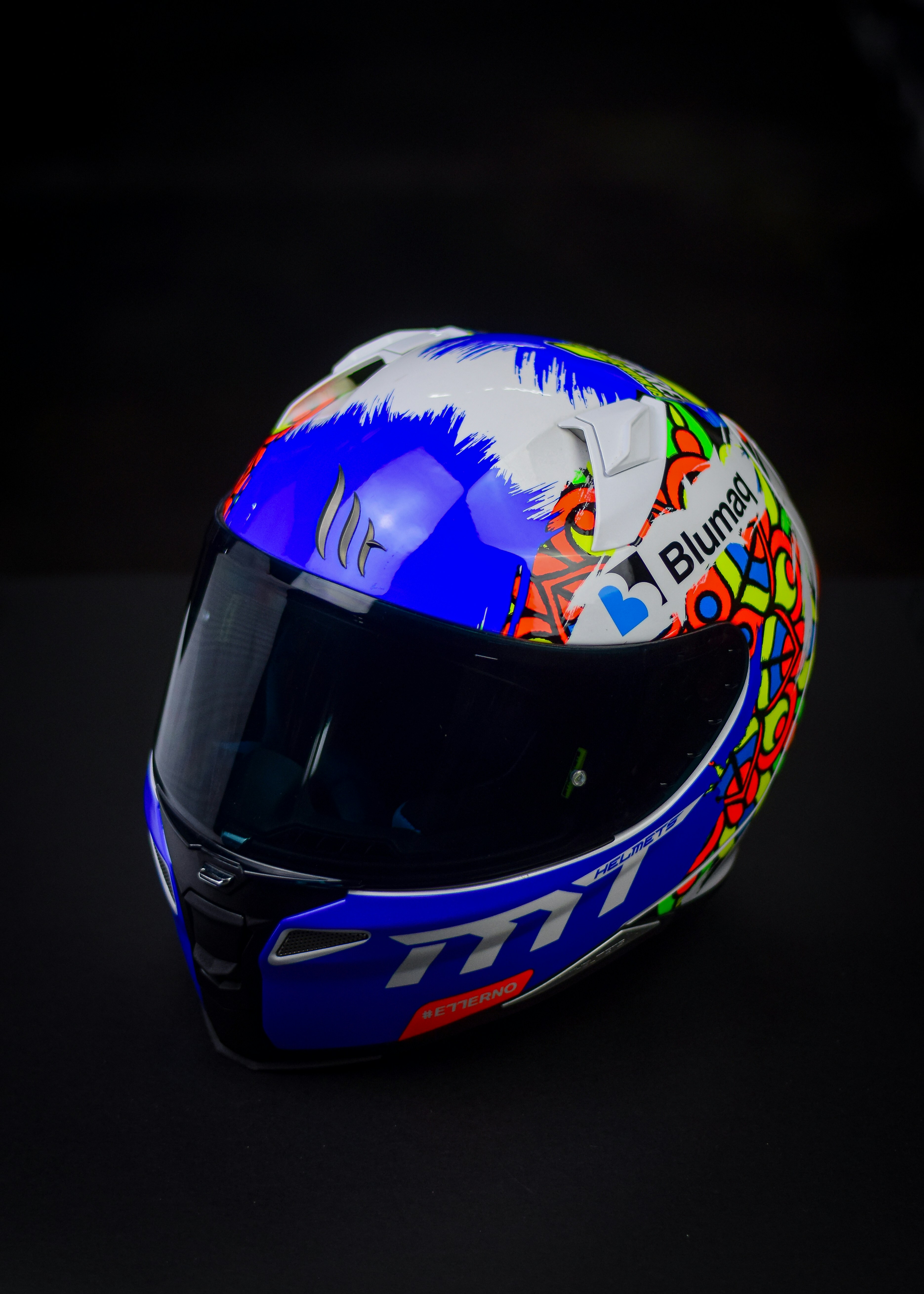 Vivid racing helmet resting on velvet darkness