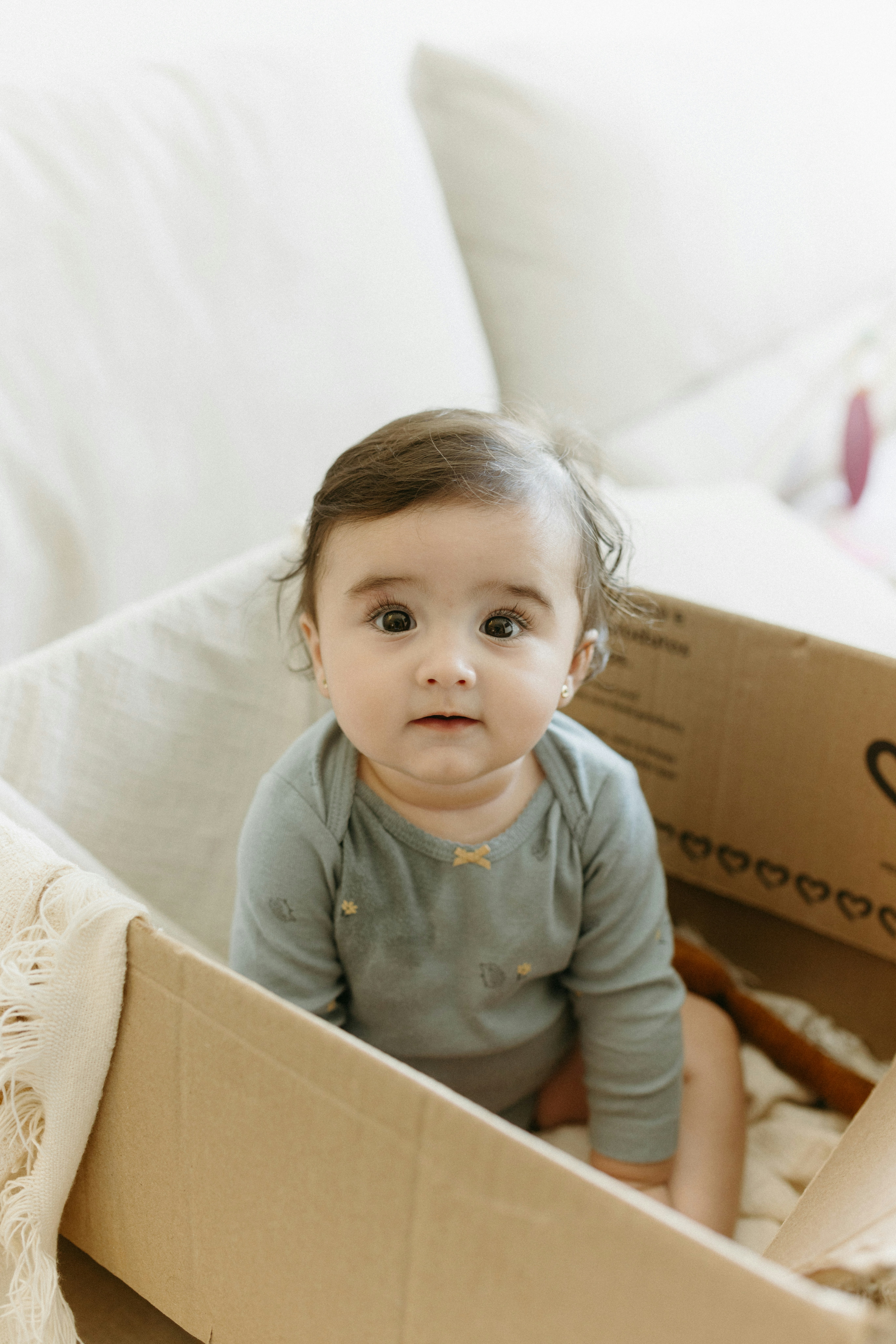 Curious Moment in a Cardboard Nest: A Baby's Quiet Gaze