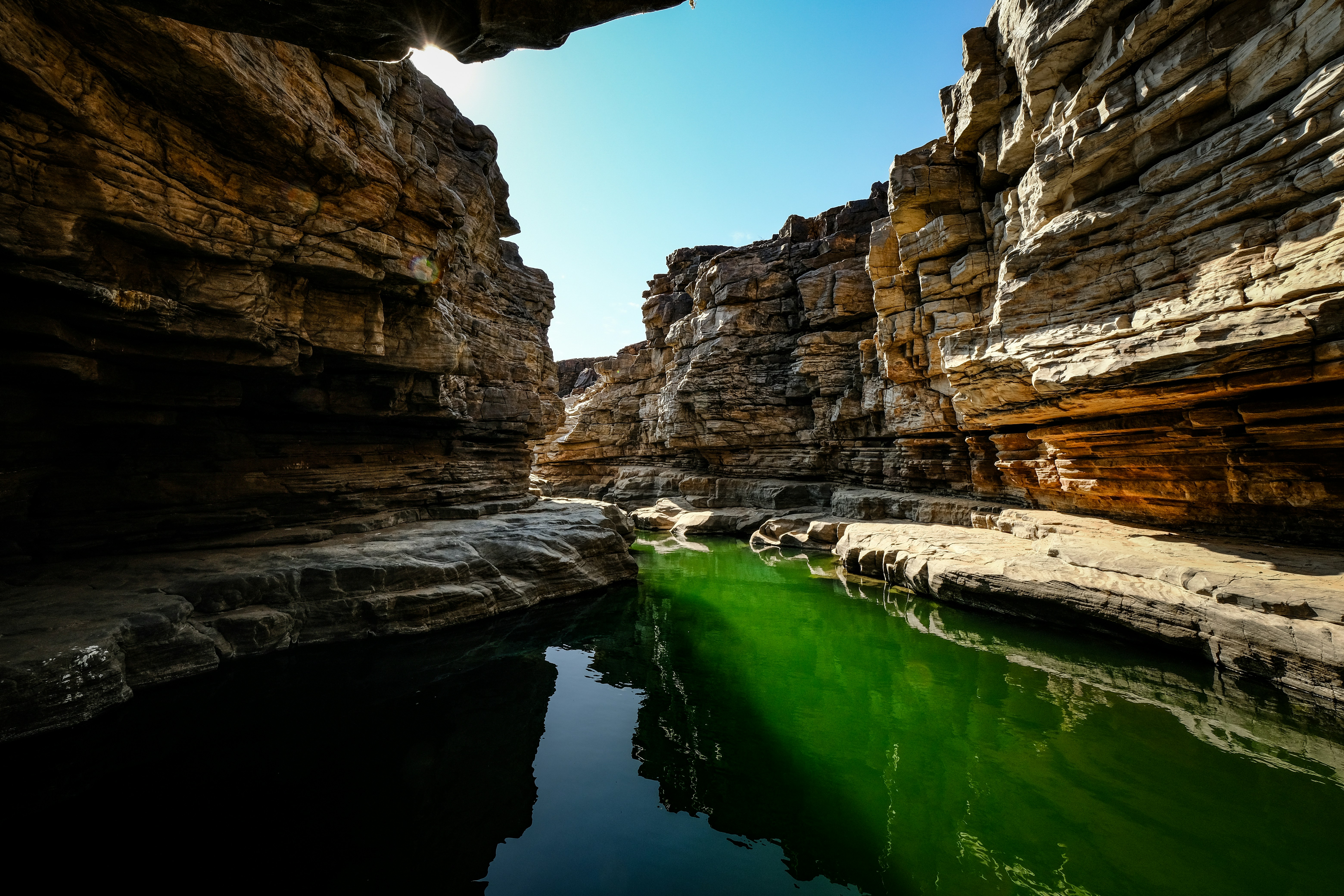 A body of water surrounded by large rocks photo – Free Lagoon Image on ...