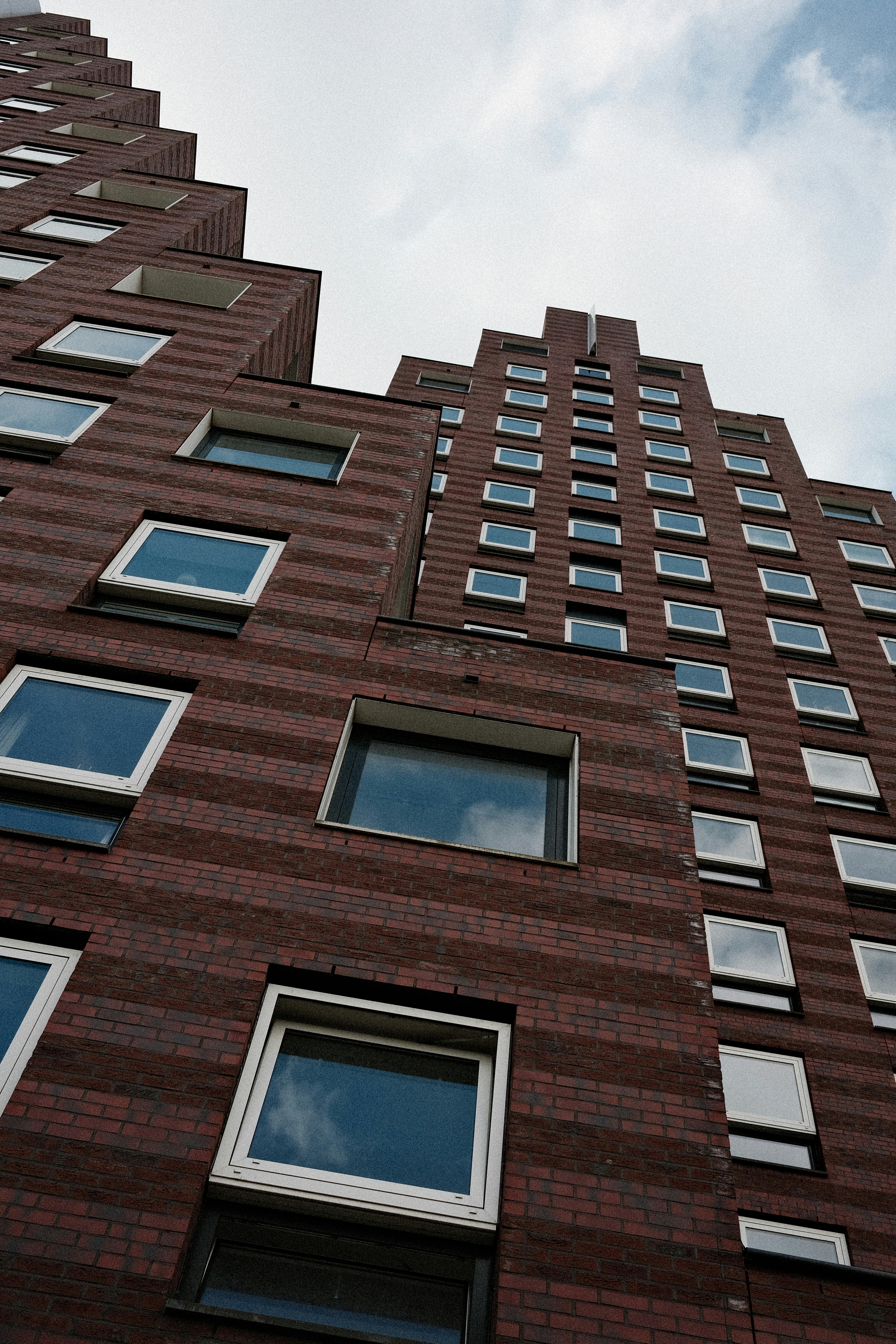 A tall red brick building with many windows photo – Free Building Image ...