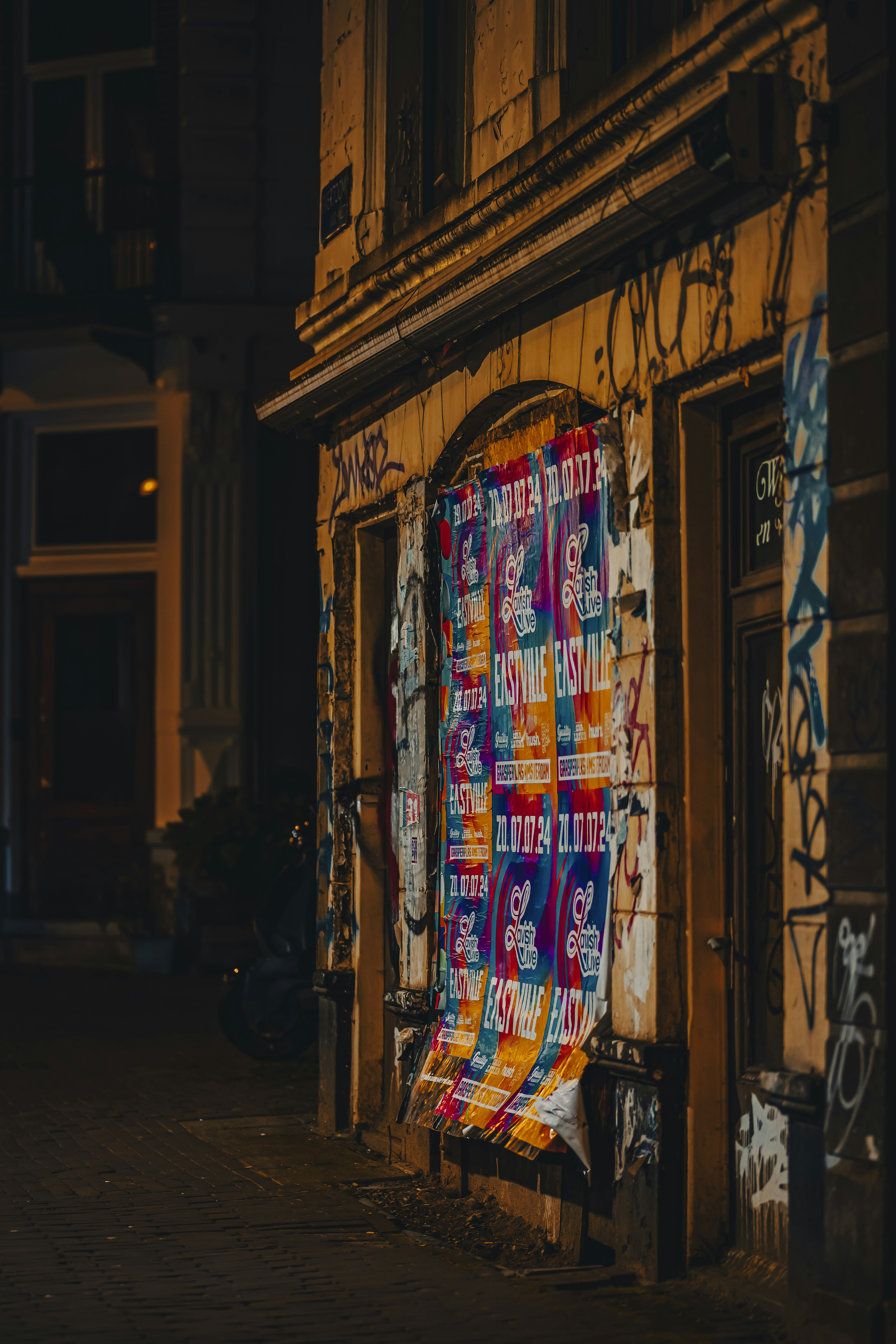 Neon-Glazed Poster Facade: A Graffiti-Wrapped Door at Night