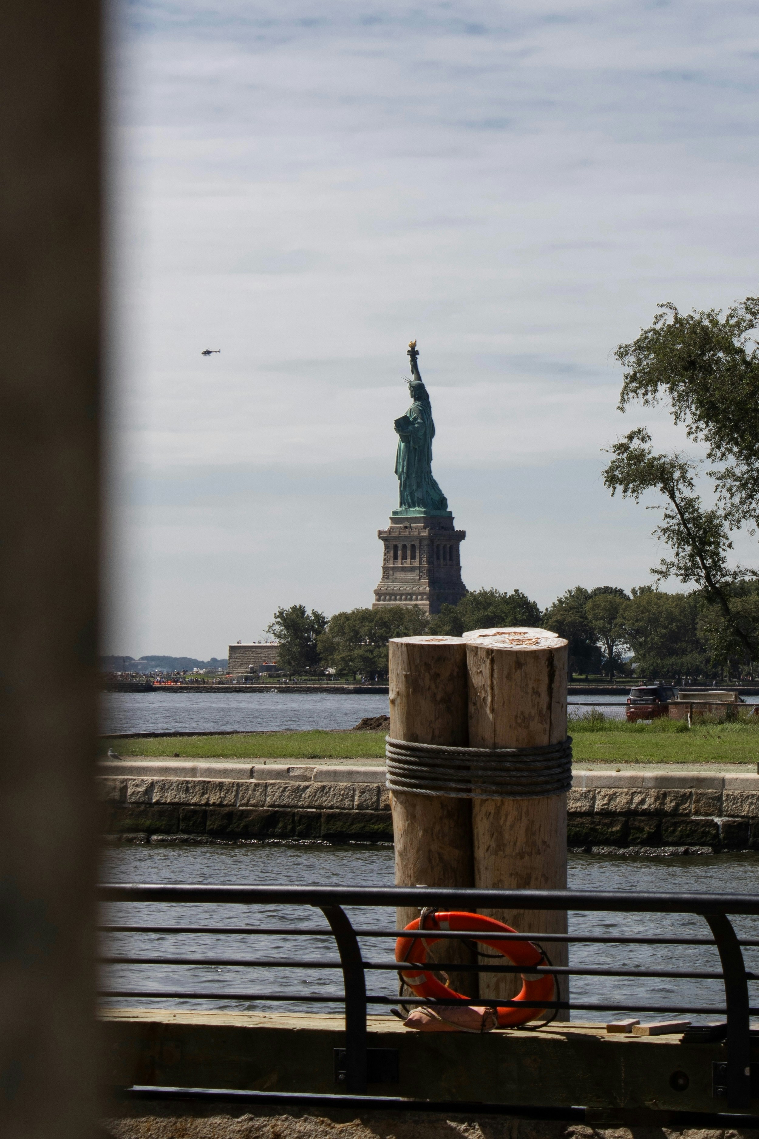 Across the Water: Lady Liberty Framed by Riverside Rails