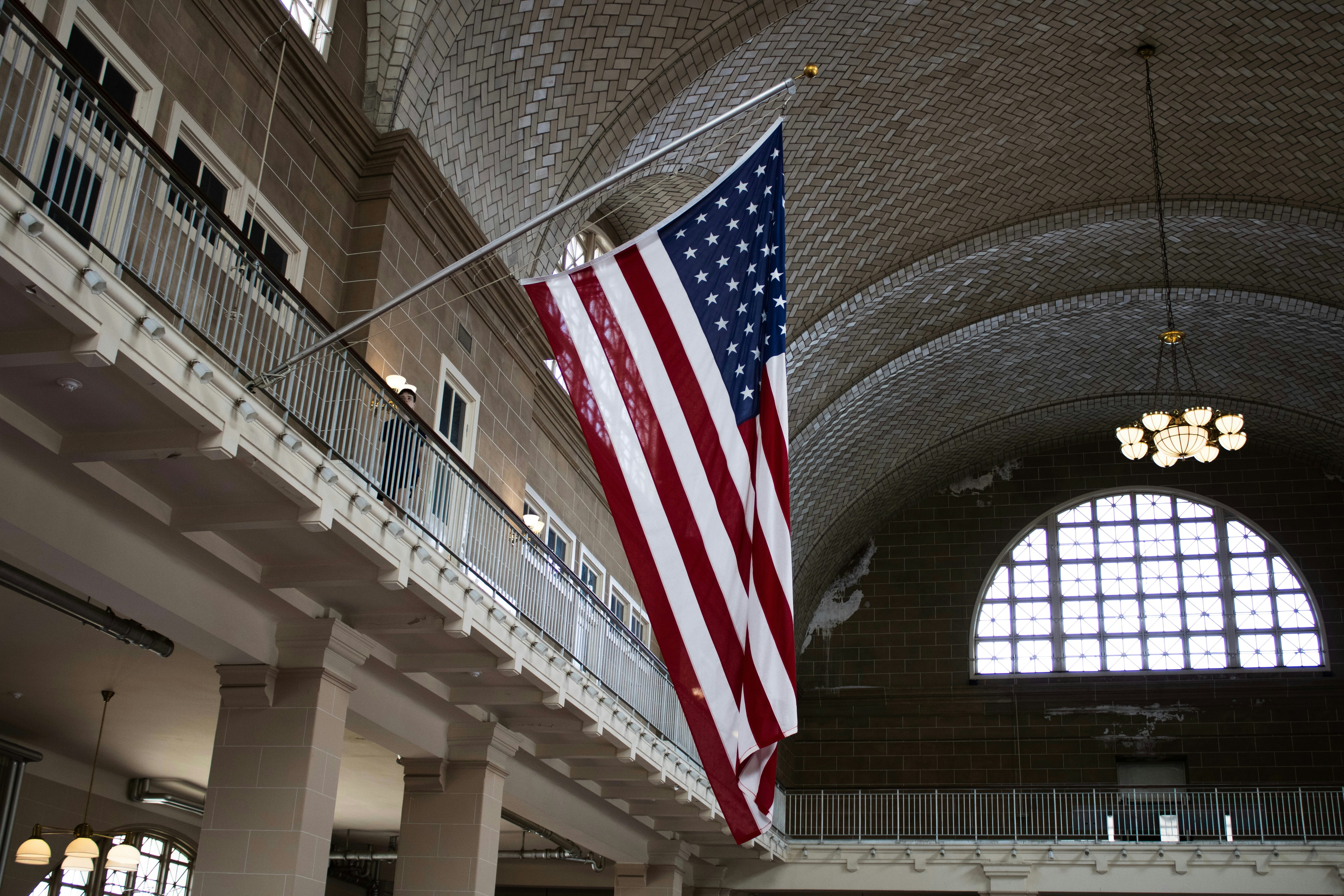 An american flag hanging from the ceiling of a building photo – Free ...